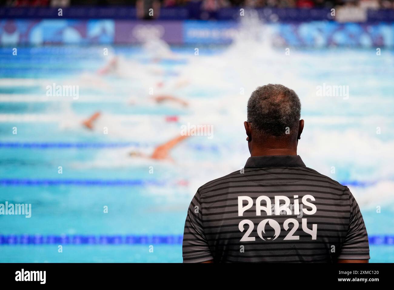 A official watches a heat of the men's 4x100m freestyle relay at the ...