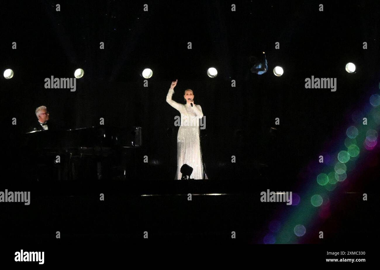 Canadian singer Celine Dion performs on the Eiffel Tower on the screen ...