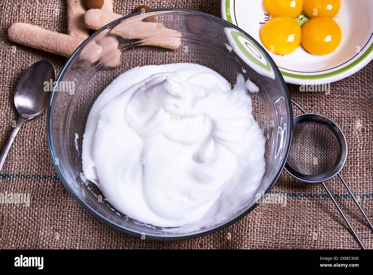 White egg foam in a transparent bowl surrounded by the bowl with the ...