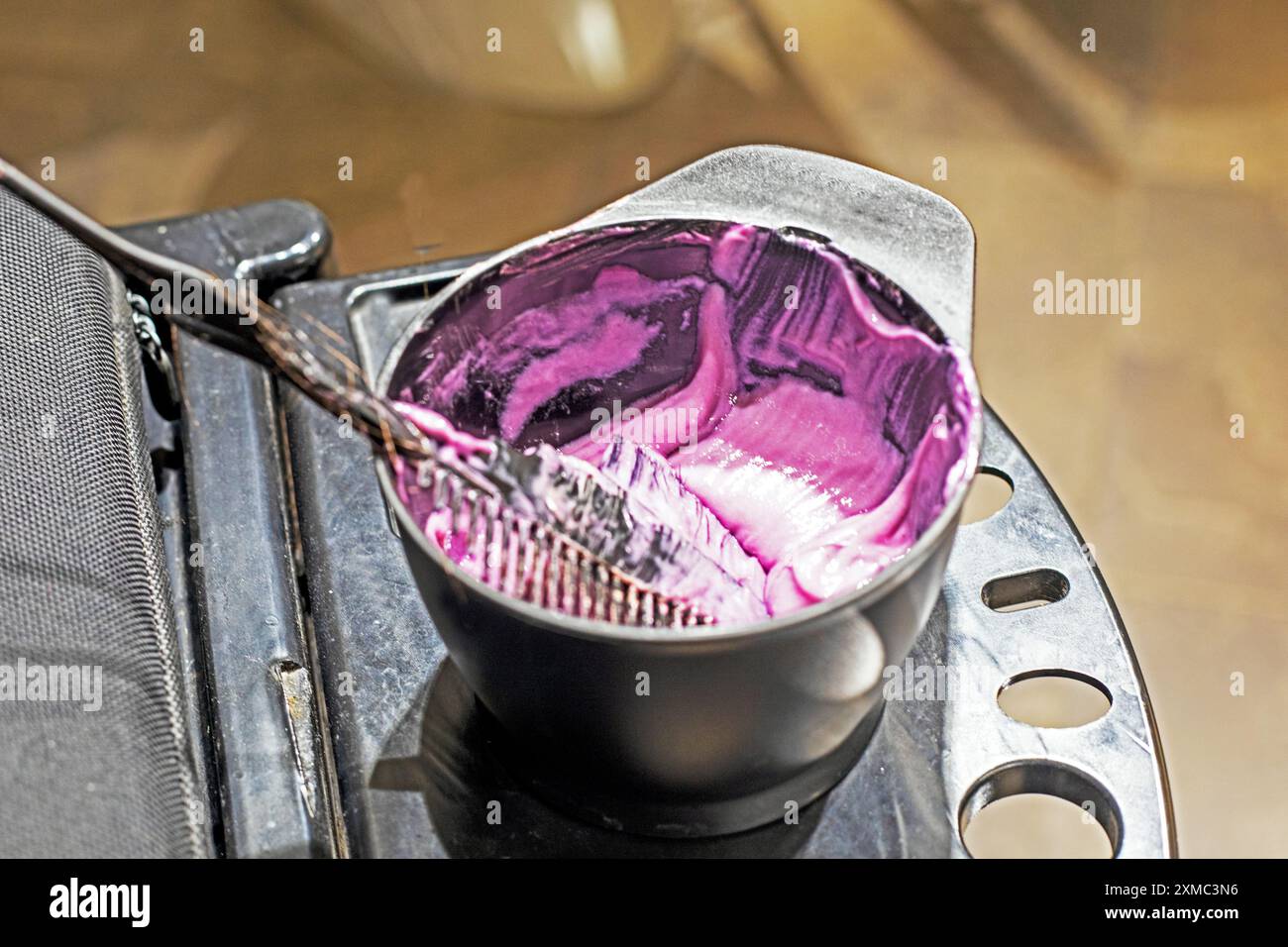 purple hair dye with a brush in a mixing container. fashion and style ...