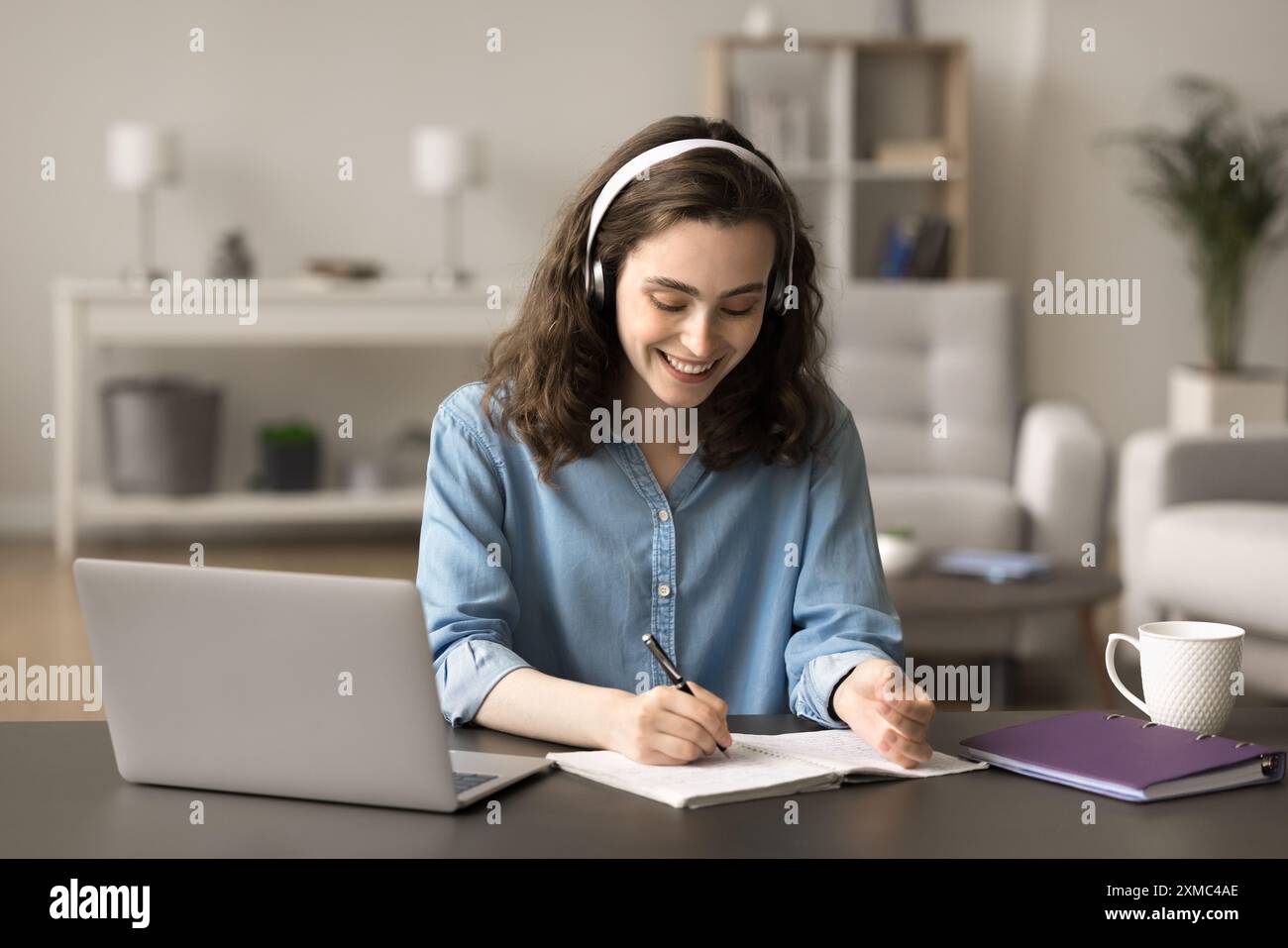 Beautiful smiling student girl makes assignment at home Stock Photo - Alamy