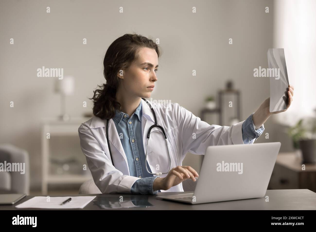 Internist holding X-ray results, review fractures of patient Stock ...