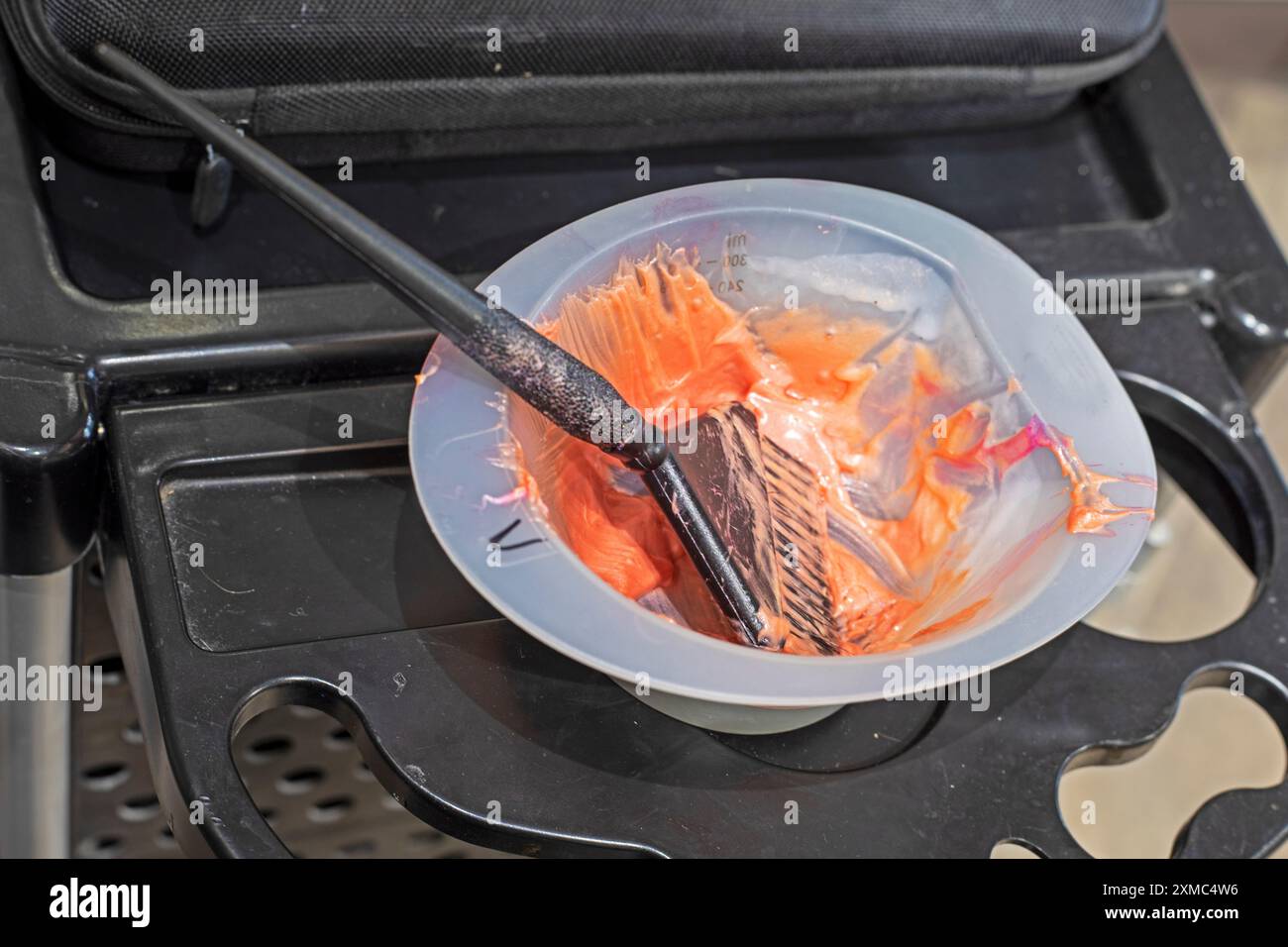purple hair dye with a brush in a container for mixing. fashion and ...