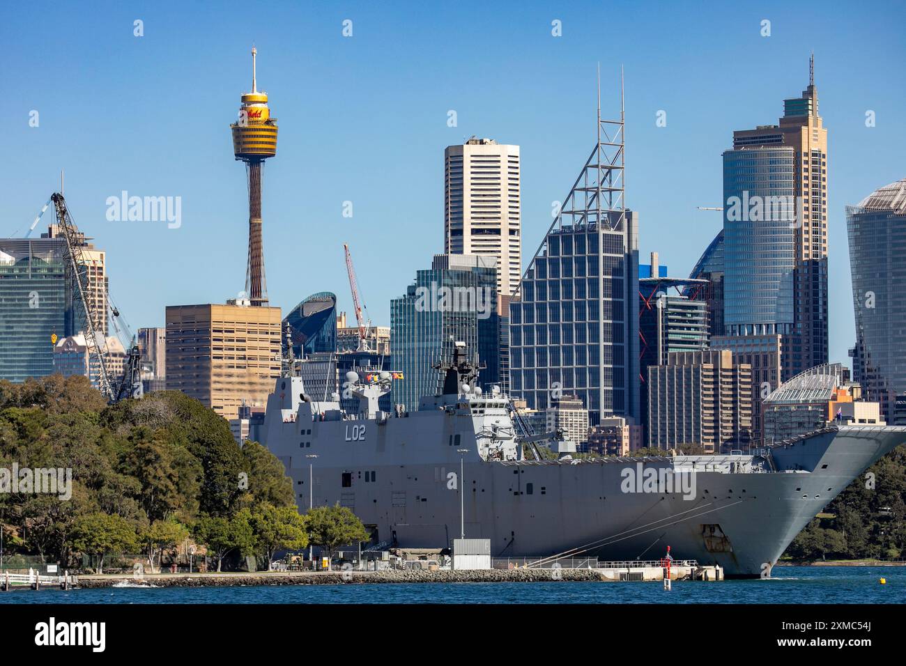 HMAS Canberra at the Garden Island naval base with Sydney eye tower and ...