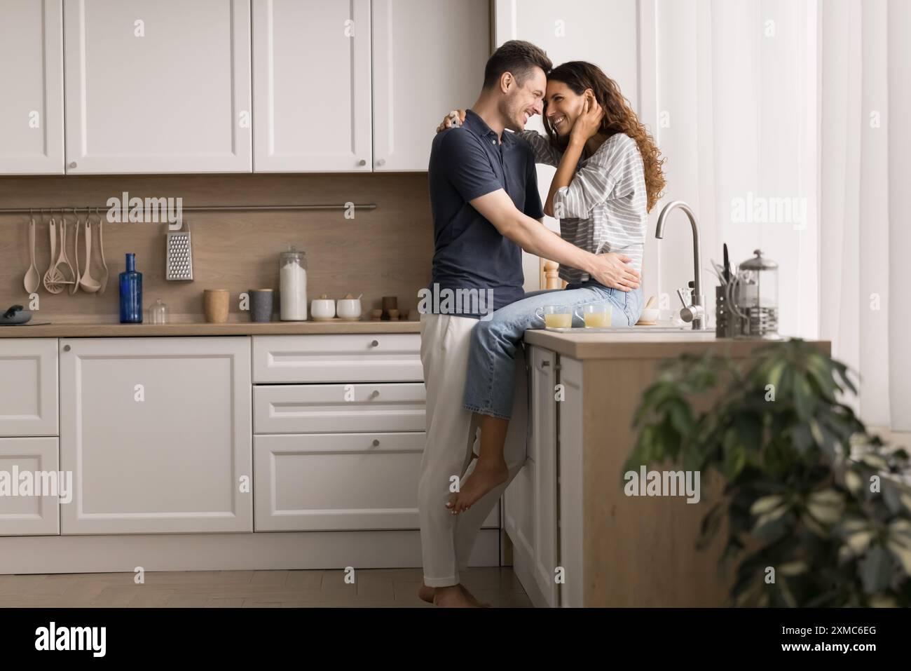 Young married couple sharing tender moment in modern kitchen Stock ...