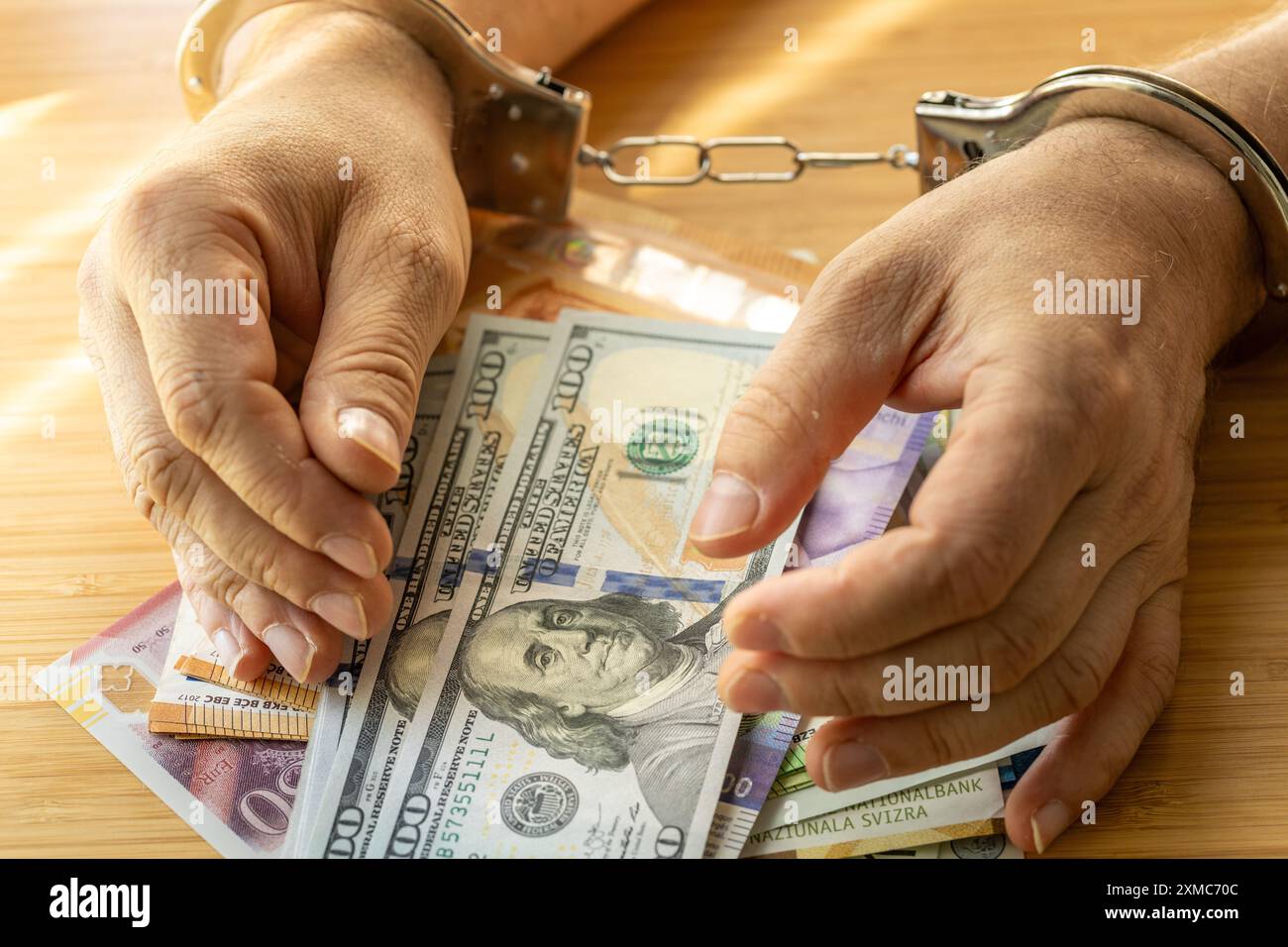 A large amount of different currencies and hands in handcuffs, concept ...