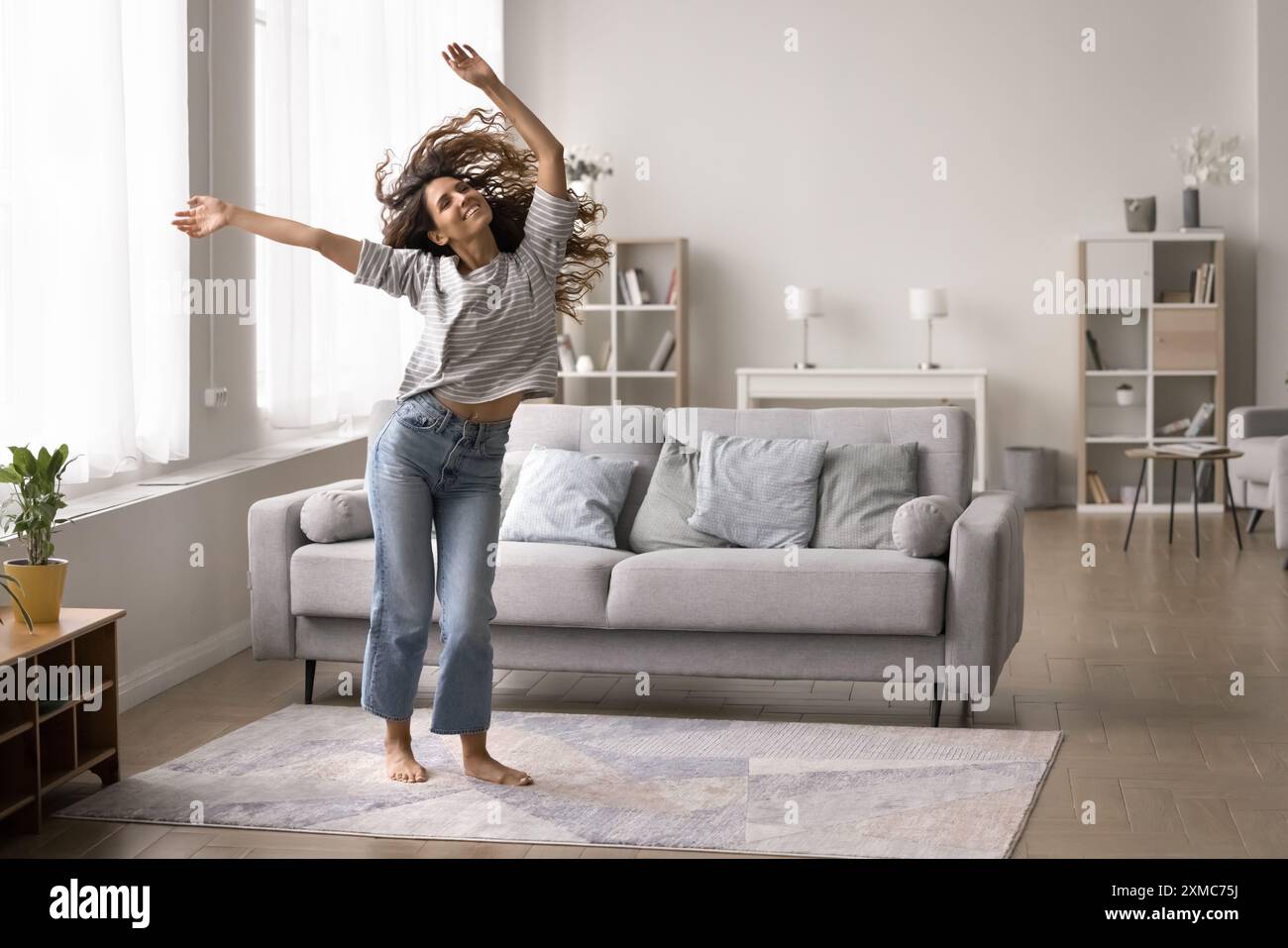 Carefree woman dancing alone in living room Stock Photo - Alamy