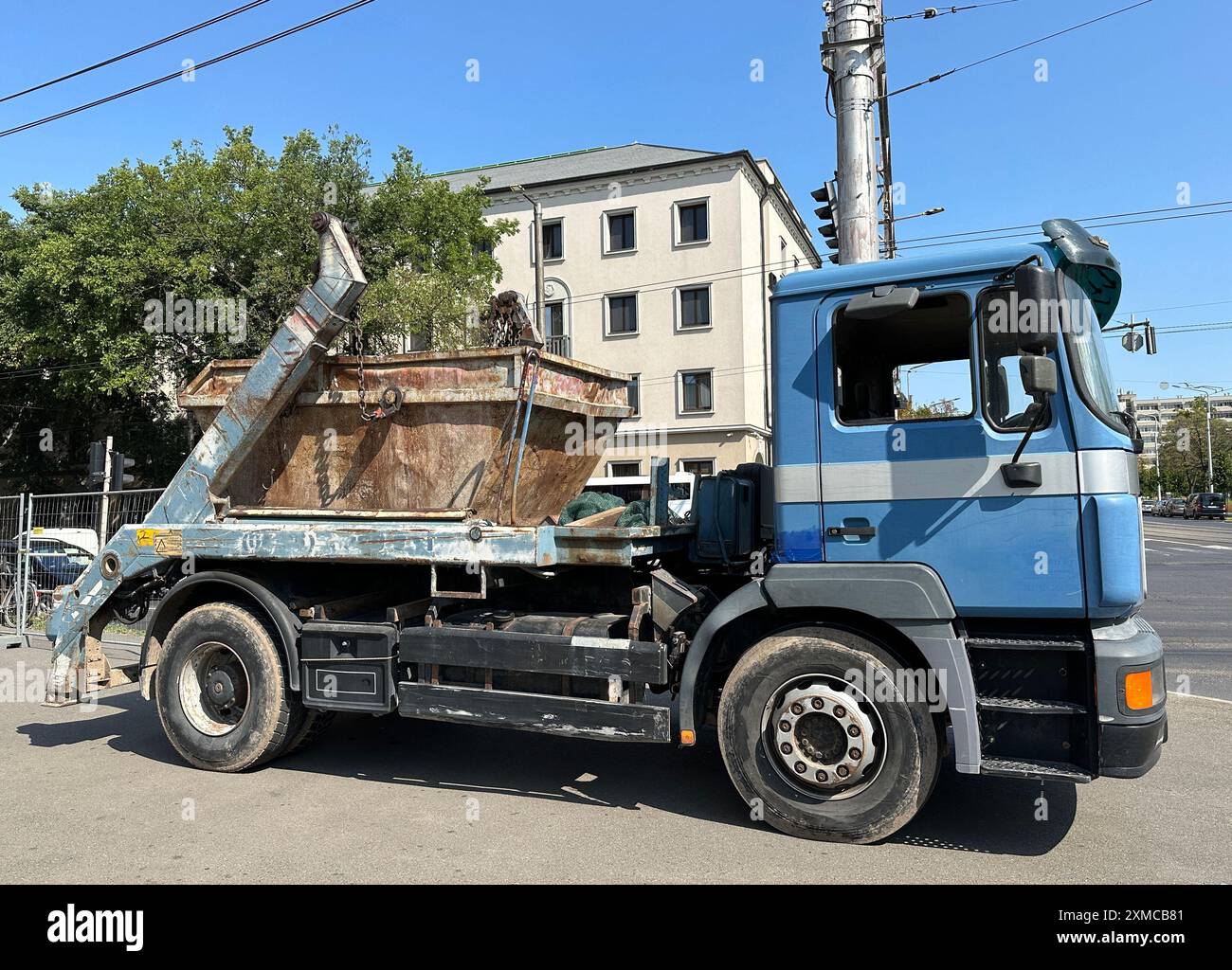 Truck with a large industrial garbage can Stock Photo - Alamy