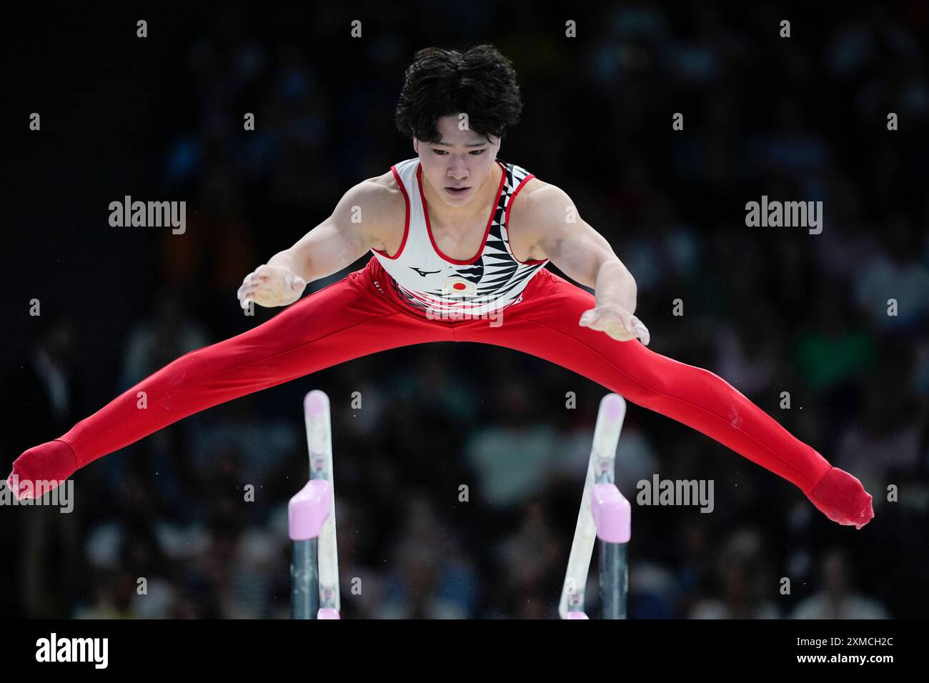 Shinnosuke Oka, of Japan, competes on the parallel bars during a men's ...