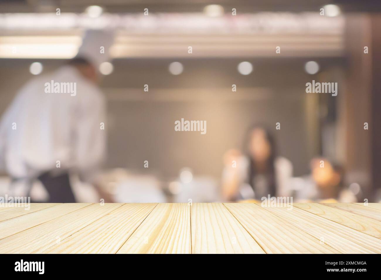 Empty wood table top with Chef cooking in restaurant kitchen abstract ...