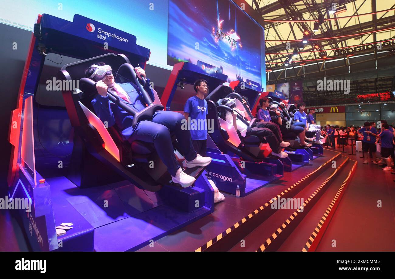 Visitors try the XR experience in the rotating chairs in the booth of ...