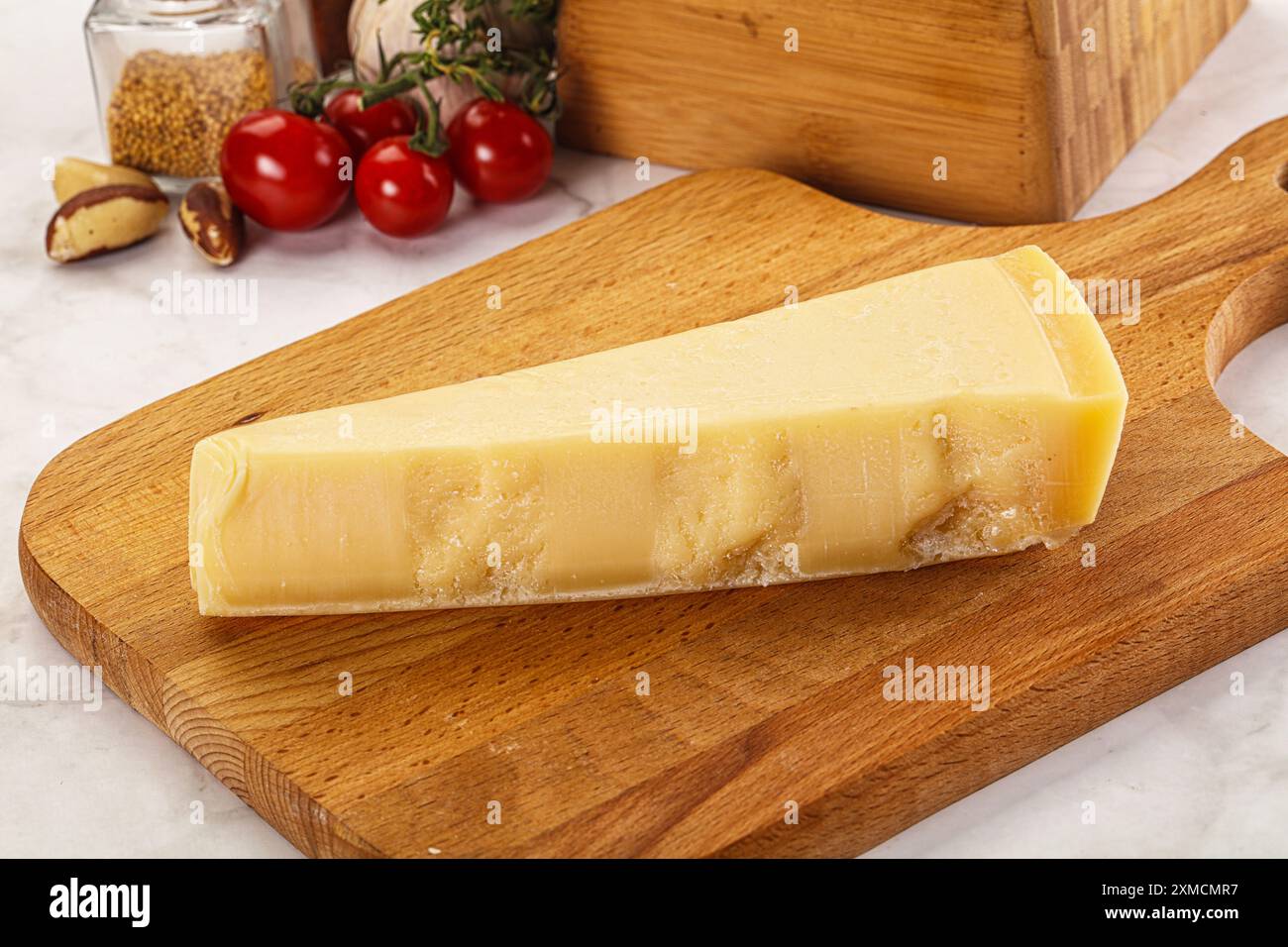 Hard parmesan cheese piece triangle over board Stock Photo - Alamy