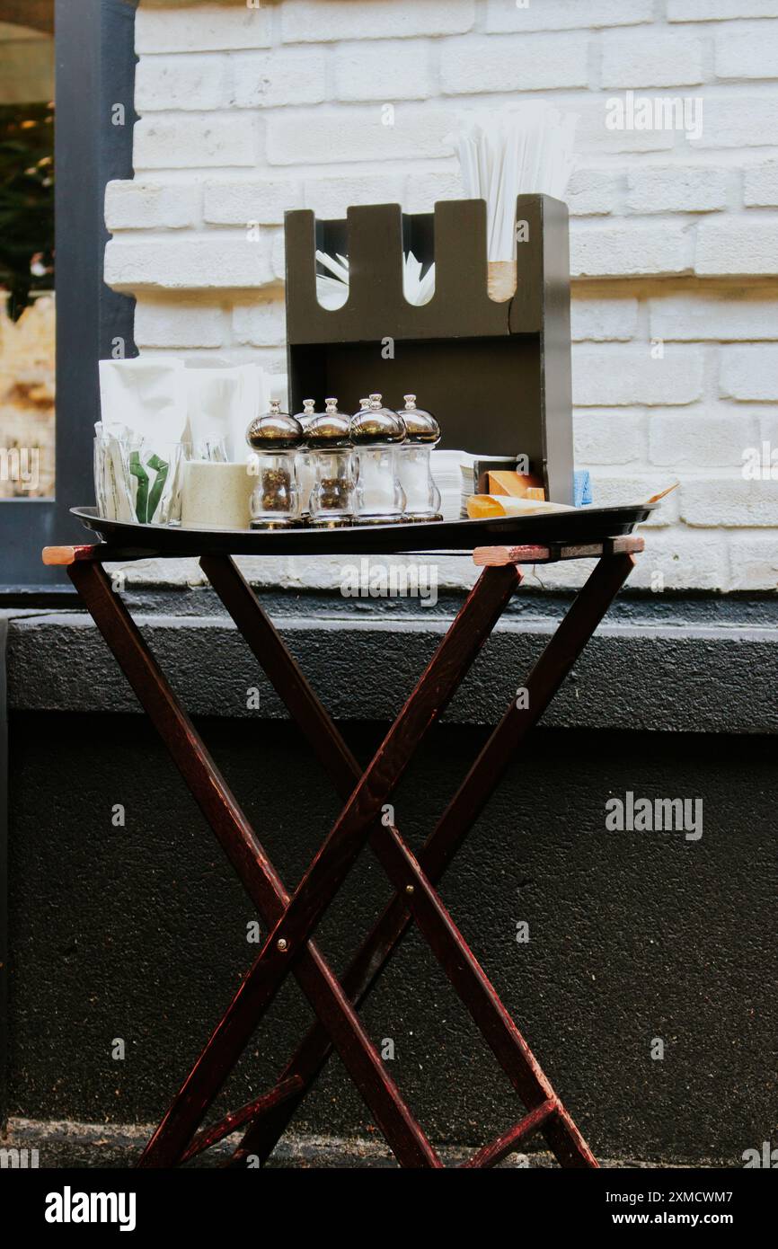Table set with pepper, salt and napkins. Sidewalk cafe furniture ...