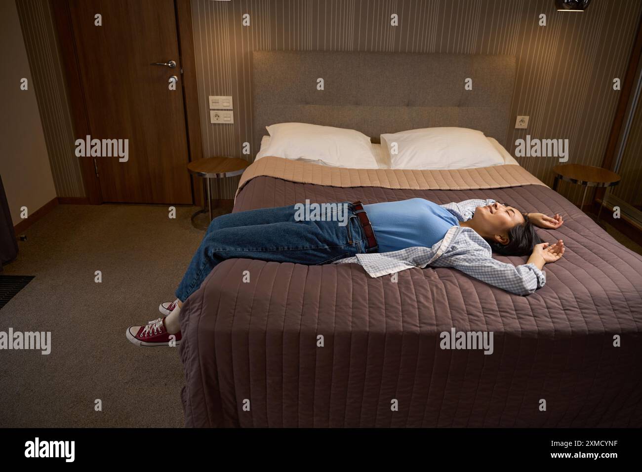 Asian woman lying across double bed in hotel room and resting Stock ...