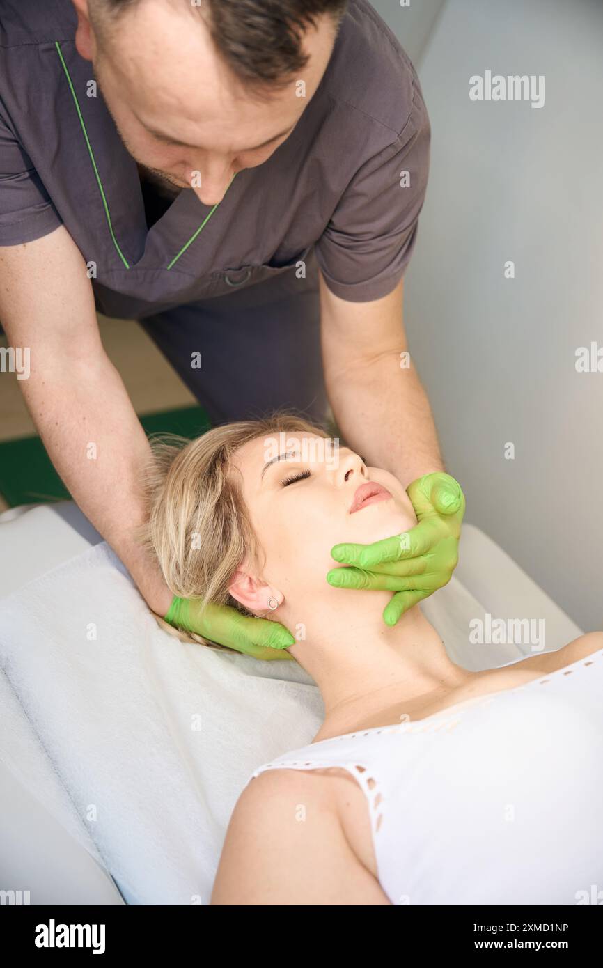 Chiropractor conducting cranial osteopathy on female patient Stock ...