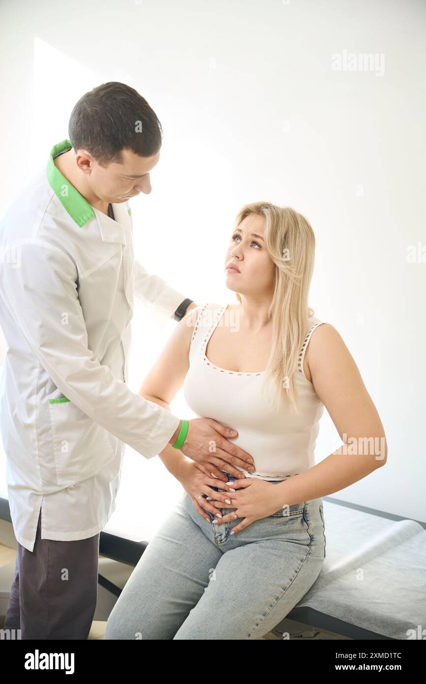 Female patient with stomachache being examined by doctor Stock Photo ...