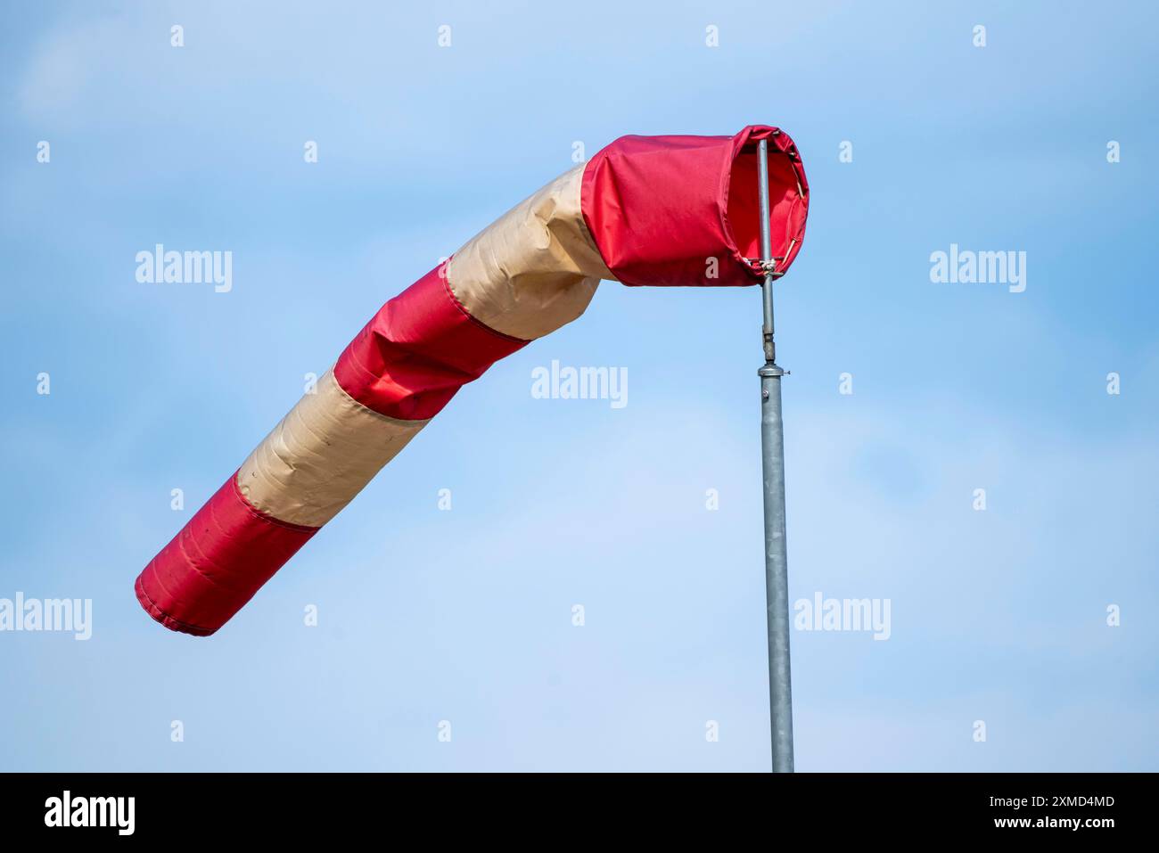 Red and white windsock at an airport, indicates wind direction and ...