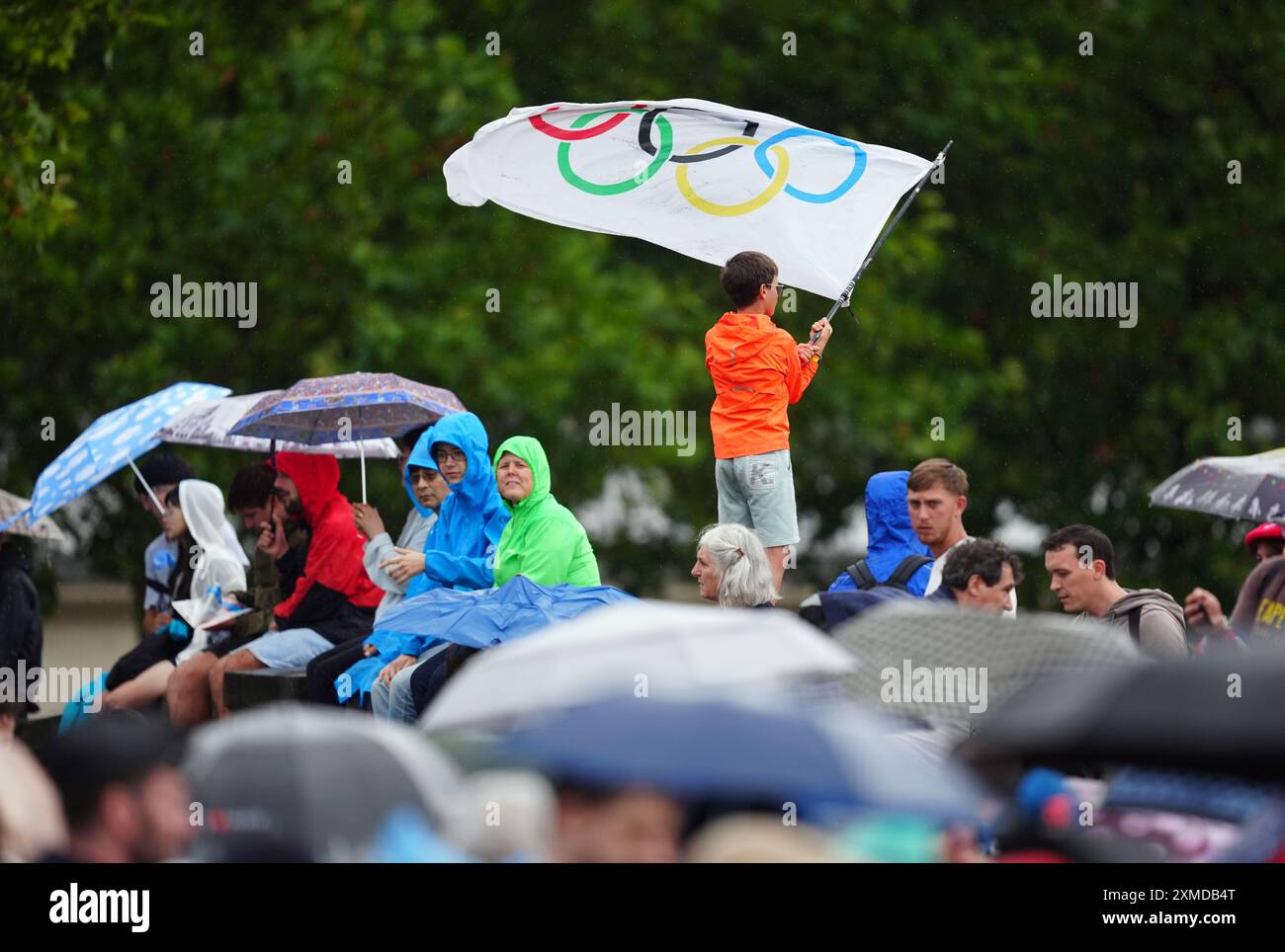 A young spectator waves an IOC flag during the Men's Individual Time ...