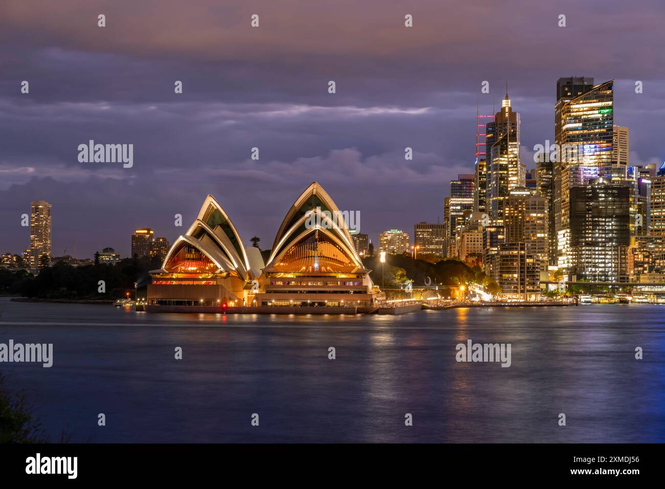 The Opera House and office towers illuminated at night in Sydney ...