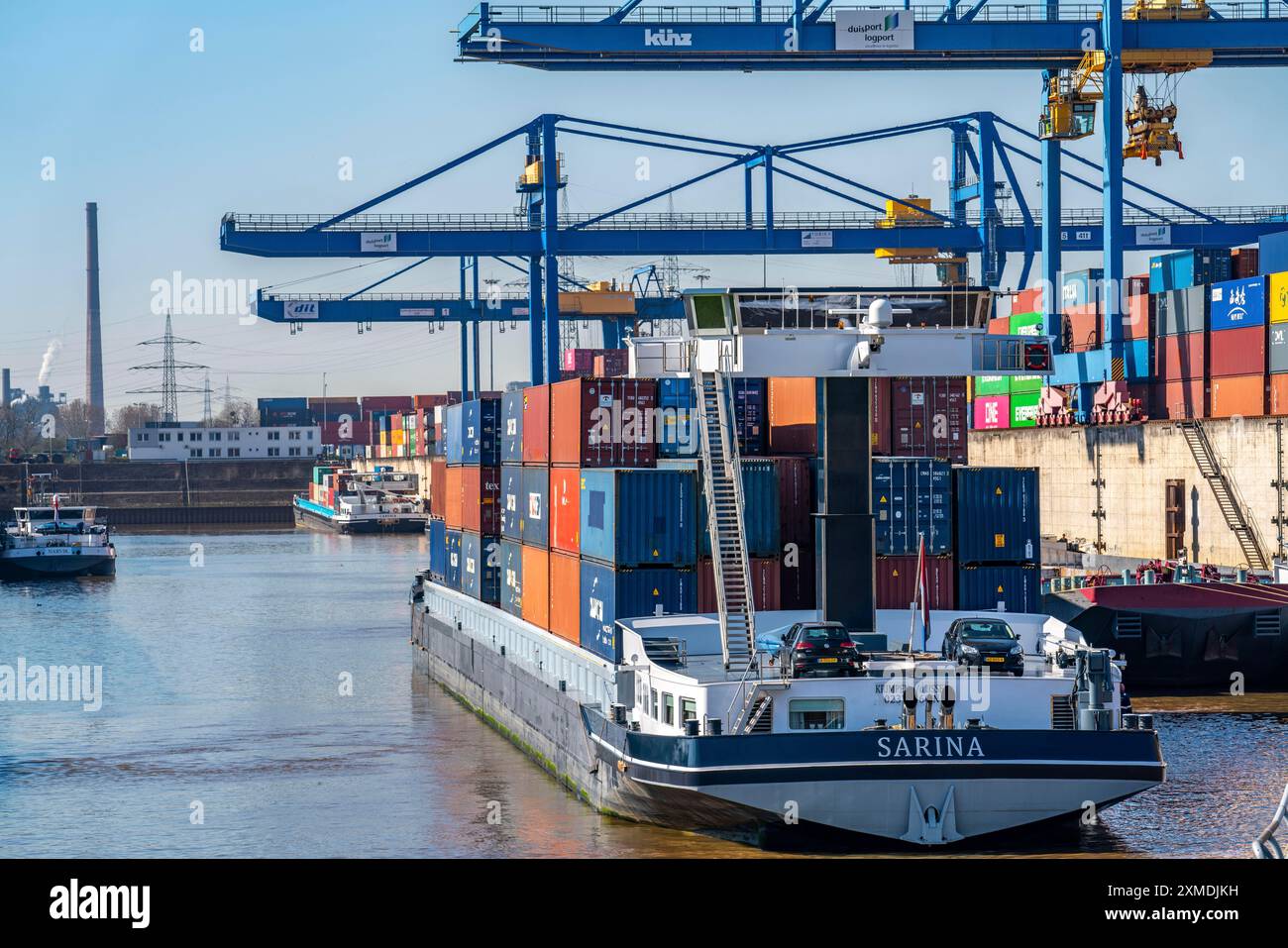 Container cargo ship enters the port basin of the Logport, gantry ...