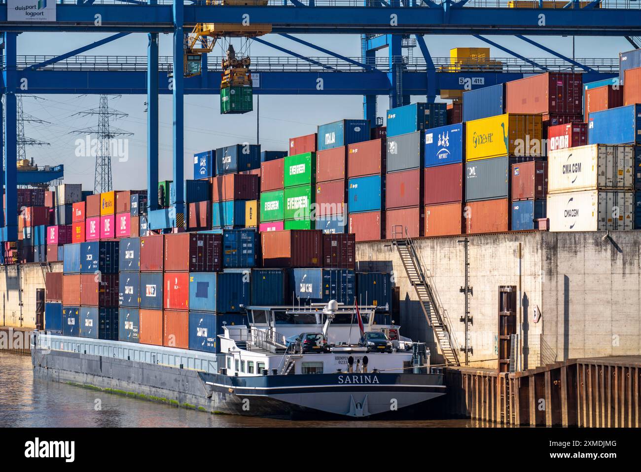 Container cargo ship in the harbour basin of the Logport, gantry cranes ...