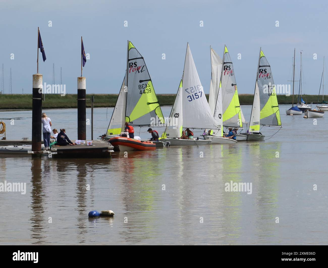 Flotilla of RS Feva dinghies arrive at the pier at Orford Quay with ...