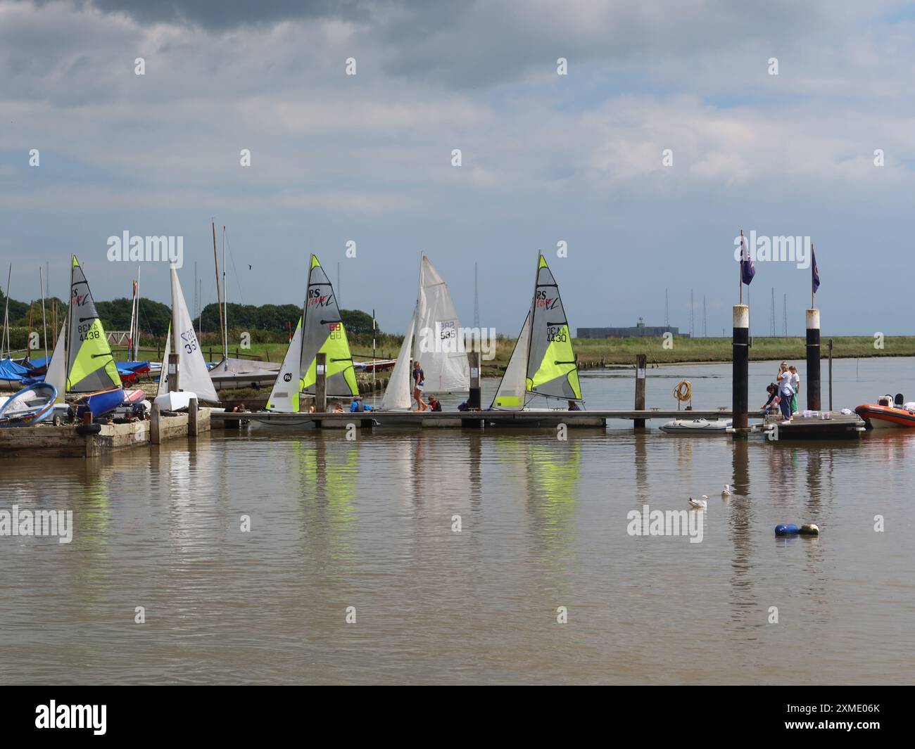 Flotilla of RS Feva dinghies arrive at the pier at Orford Quay with ...