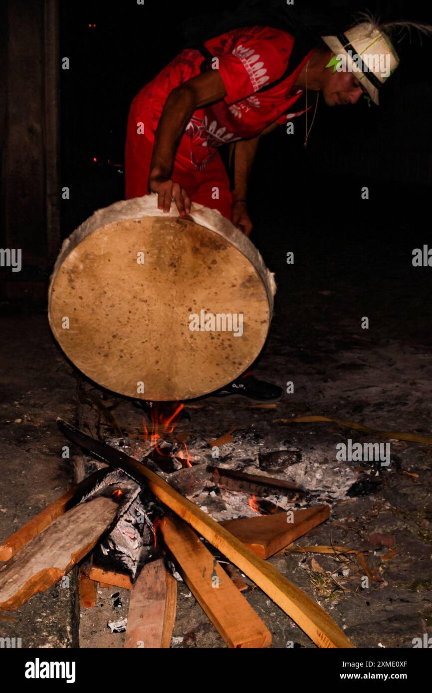 Percussionist tuning a large tambourine on fire to play the festivities ...
