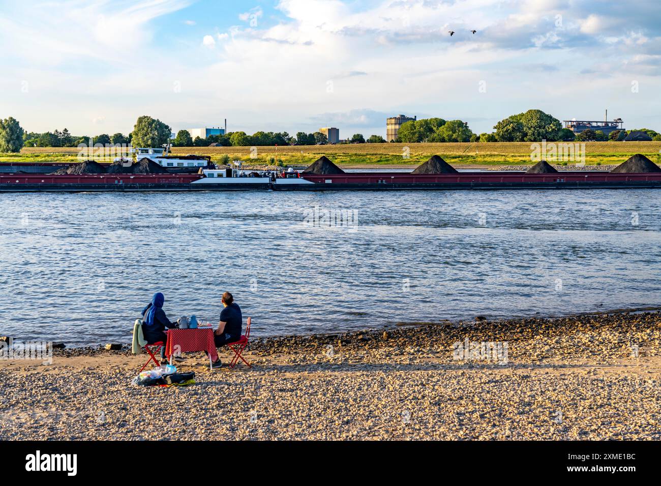 The Rhine at Duisburg-Baerl, man and woman having a picnic on the Rhine ...