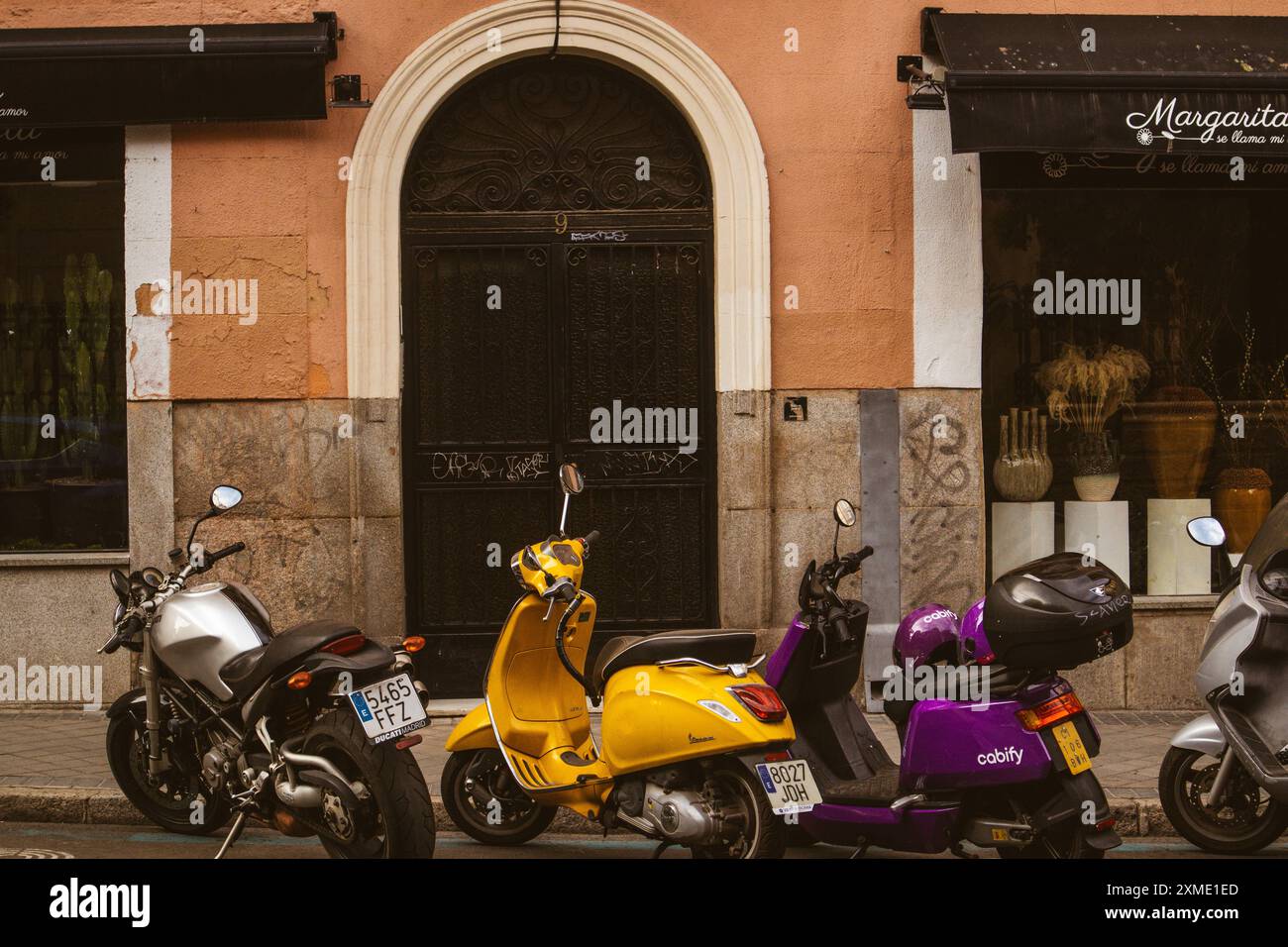 Madrid, Spain May 1, 2024 Motorcycles, motorbikes, scooter delivery services parked by a road in ...