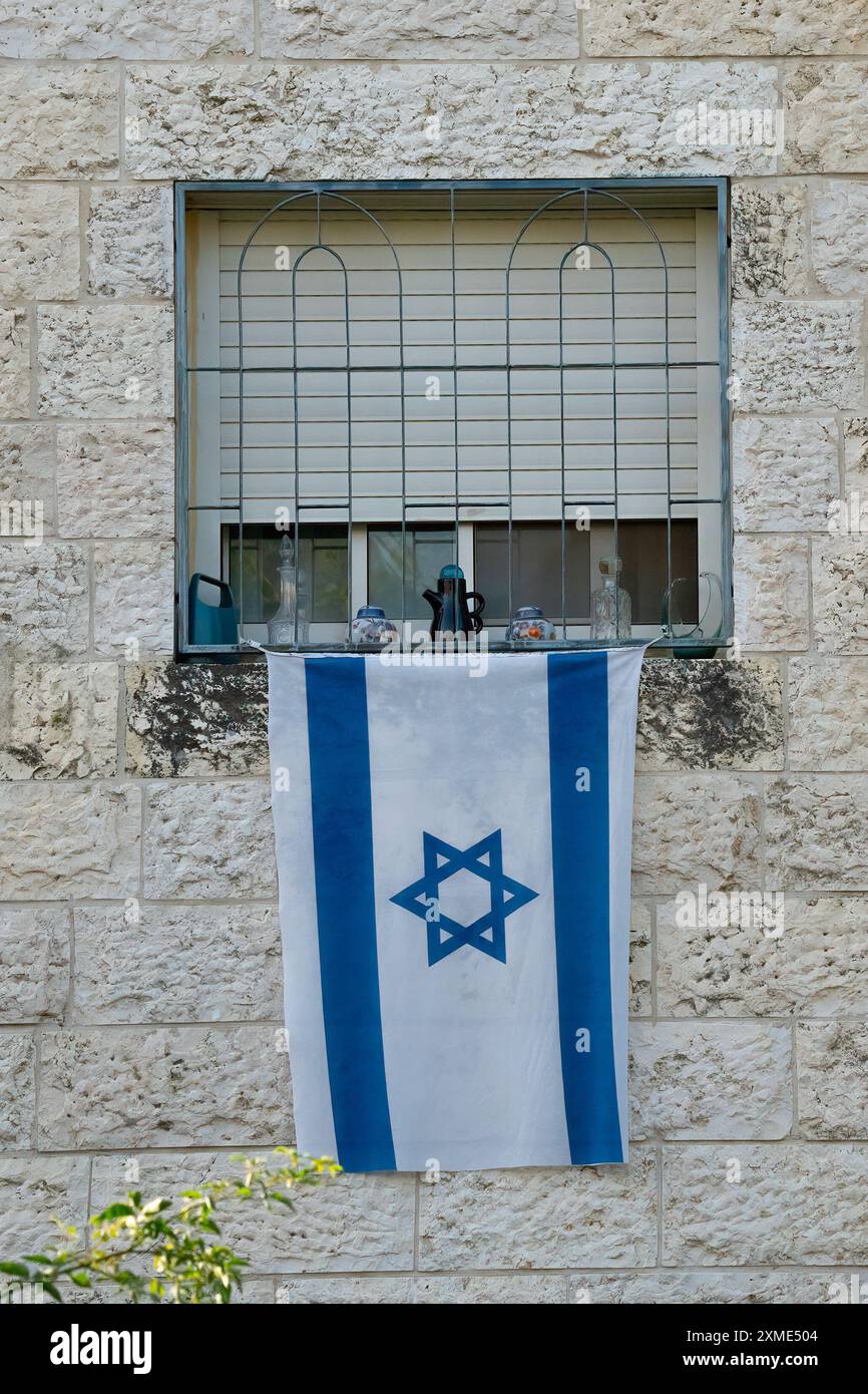 An Israeli national flag hanging from a window of a stone building in ...
