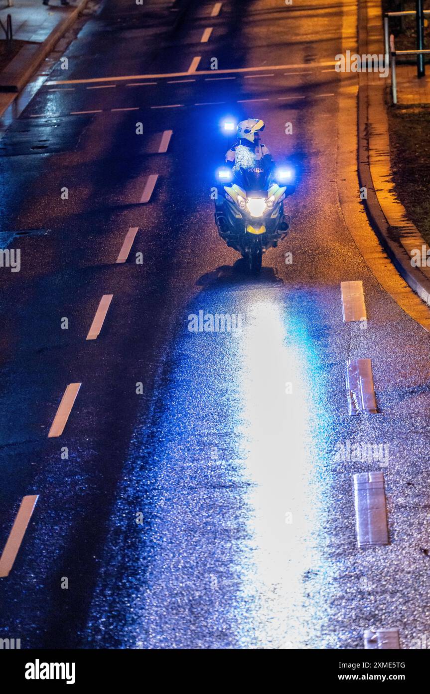 Policeman with motorbike, in rainy weather, blocking a road, police ...