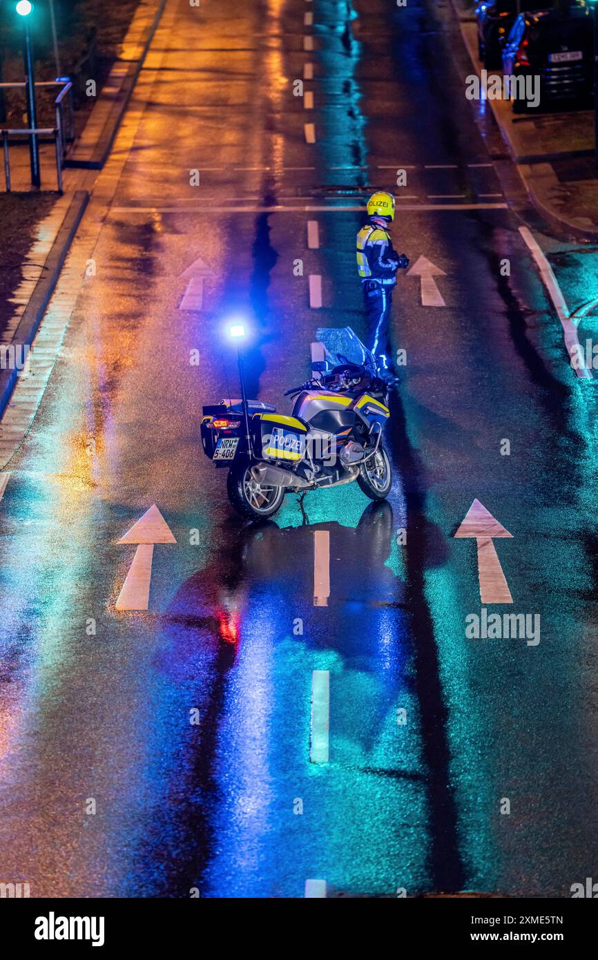 Policeman with motorbike, in rainy weather, blocking a road, police ...