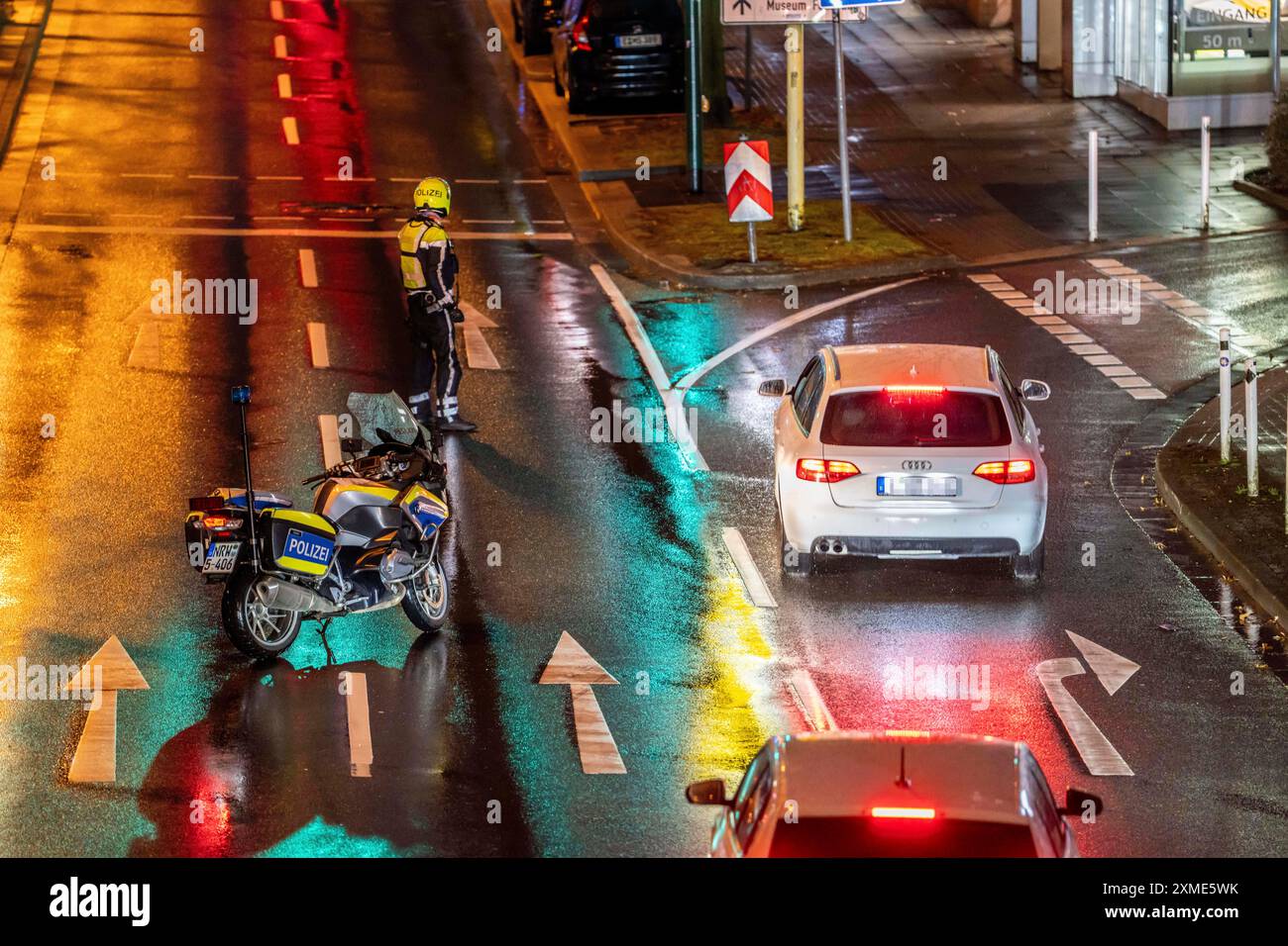 Policeman with motorbike, in rainy weather, blocking a road, police ...