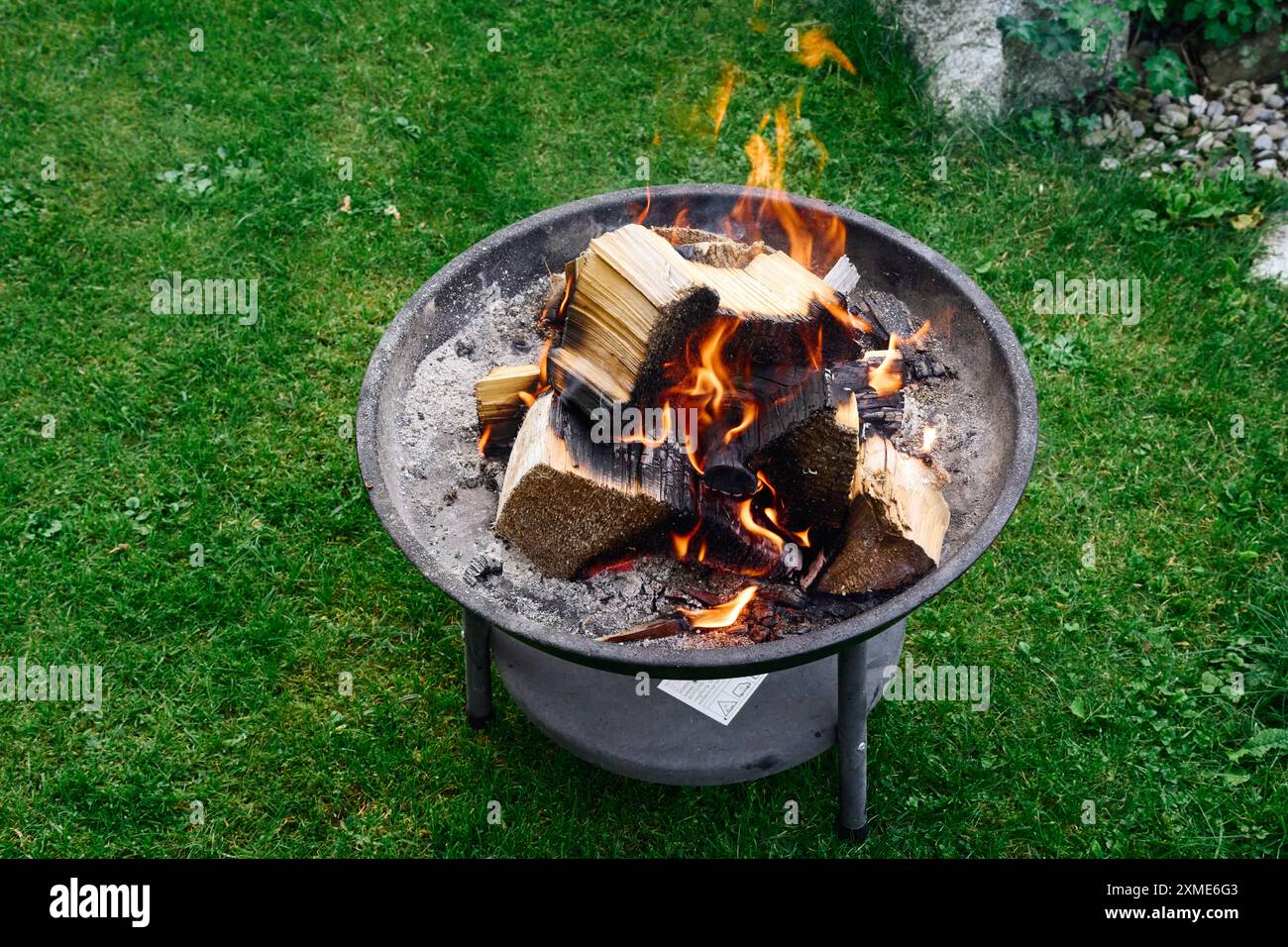 Bavaria, Germany - July 26, 2024: A fireplace in the garden with logs ...
