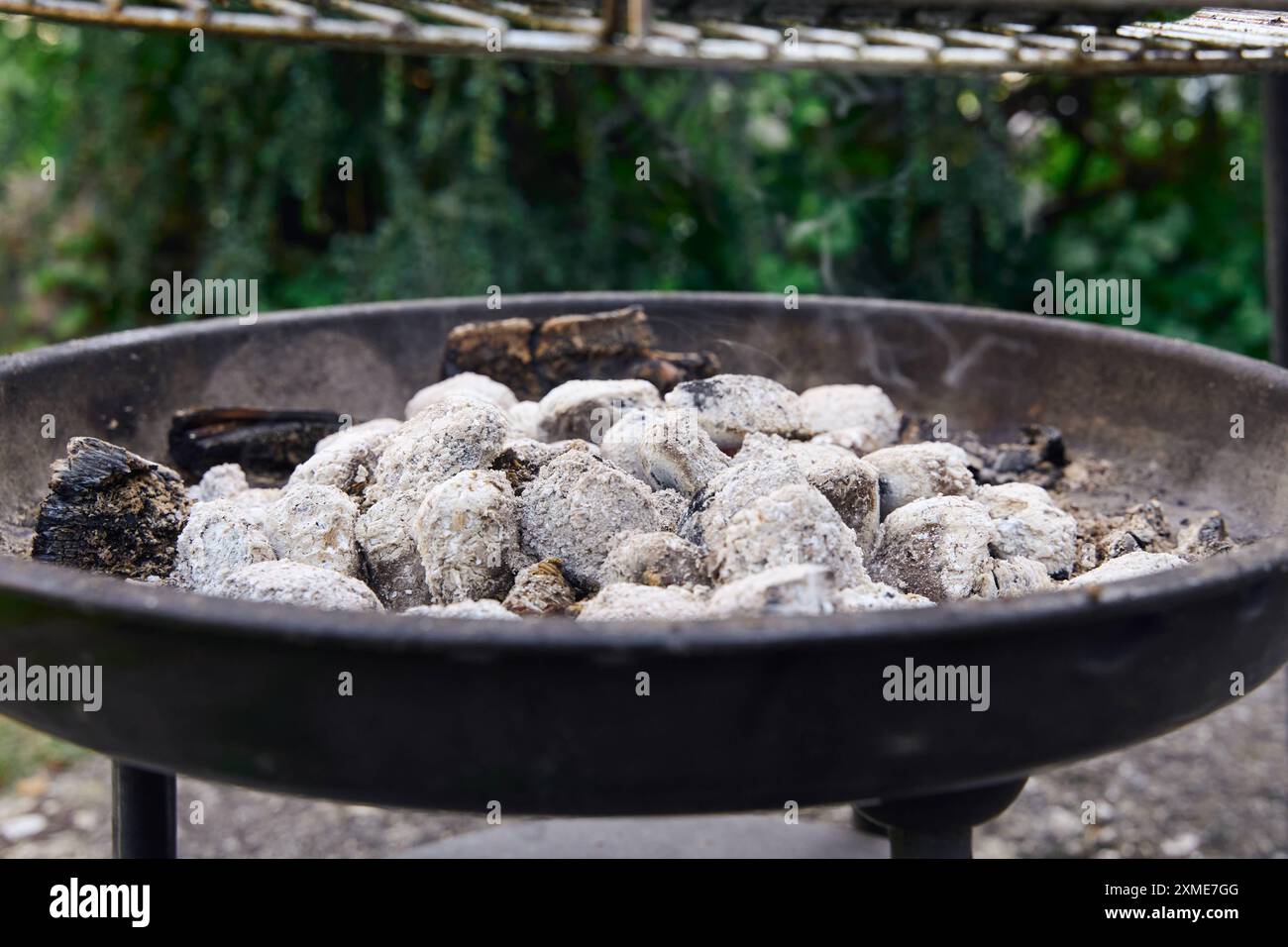 Bavaria, Germany - July 26, 2024: Glowing charcoal in the fire bowl of ...