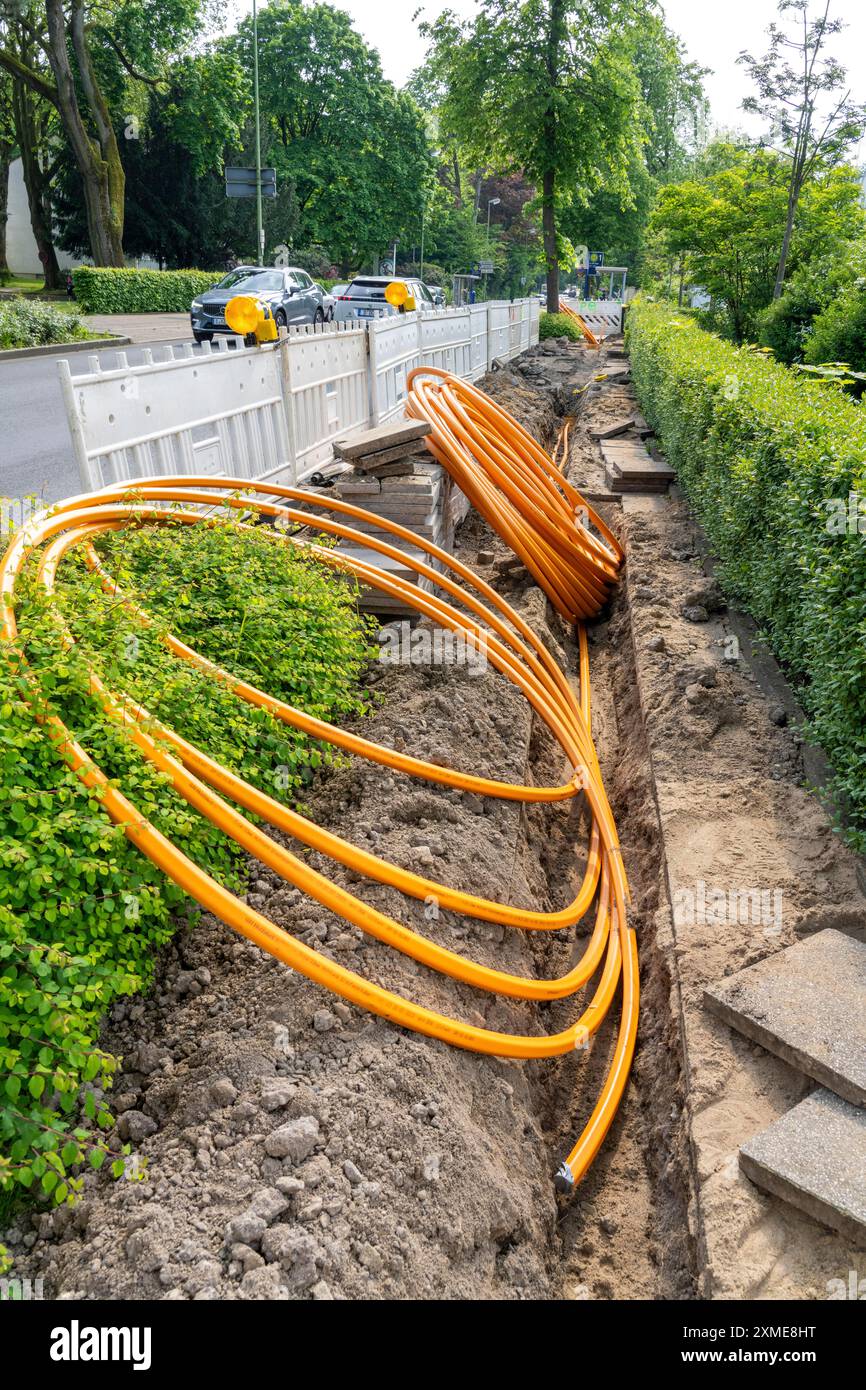 Laying of fibre optic cables, empty conduits are laid under a pavement ...