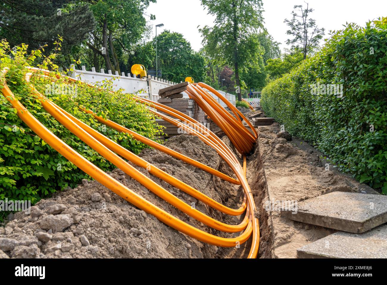 Laying of fibre optic cables, empty conduits are laid under a pavement ...