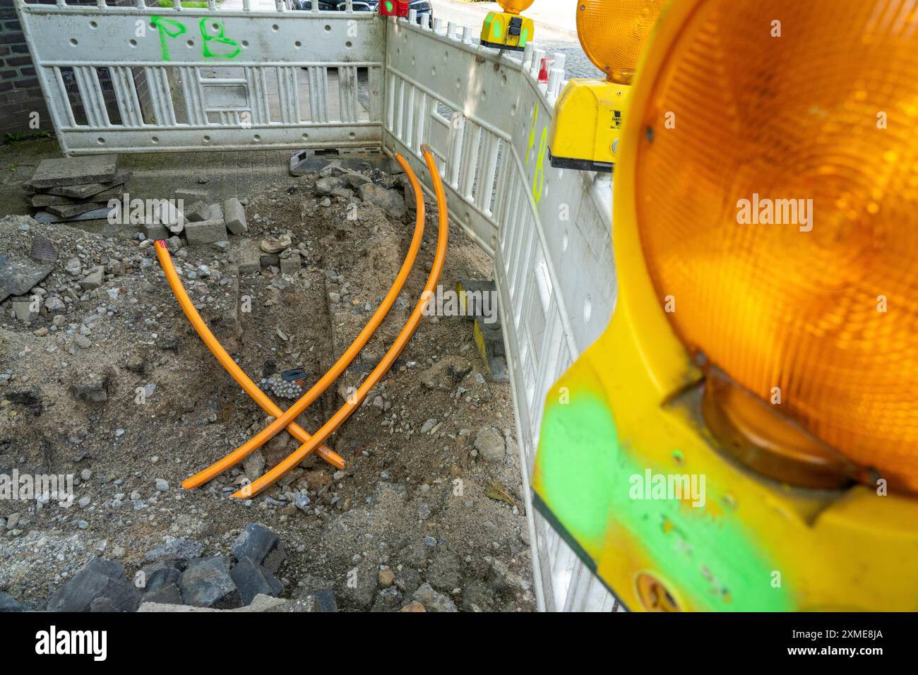Laying of fibre optic cables, empty conduits are laid under a pavement ...
