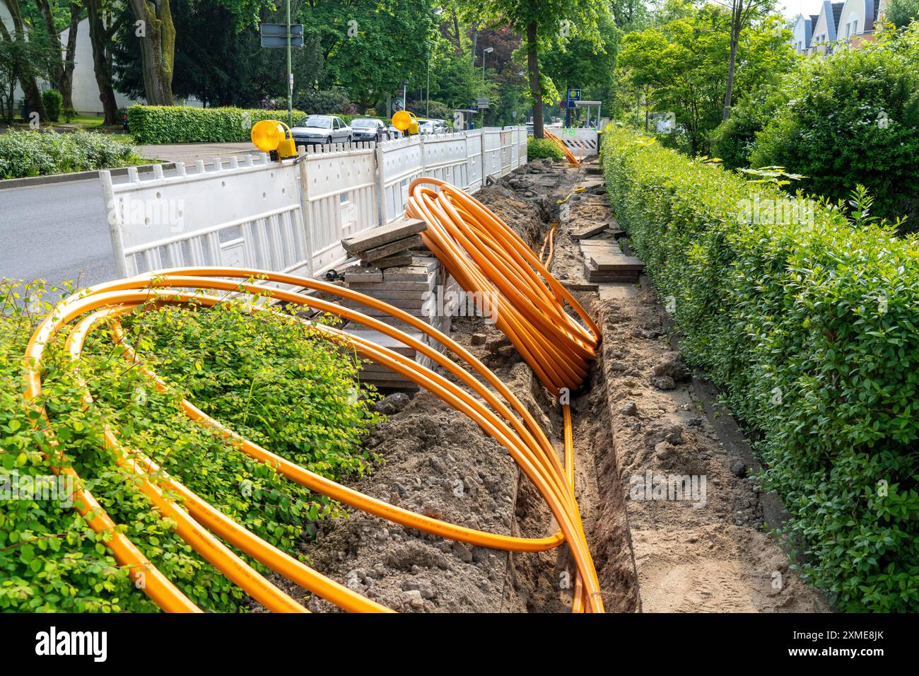 Laying of fibre optic cables, empty conduits are laid under a pavement ...