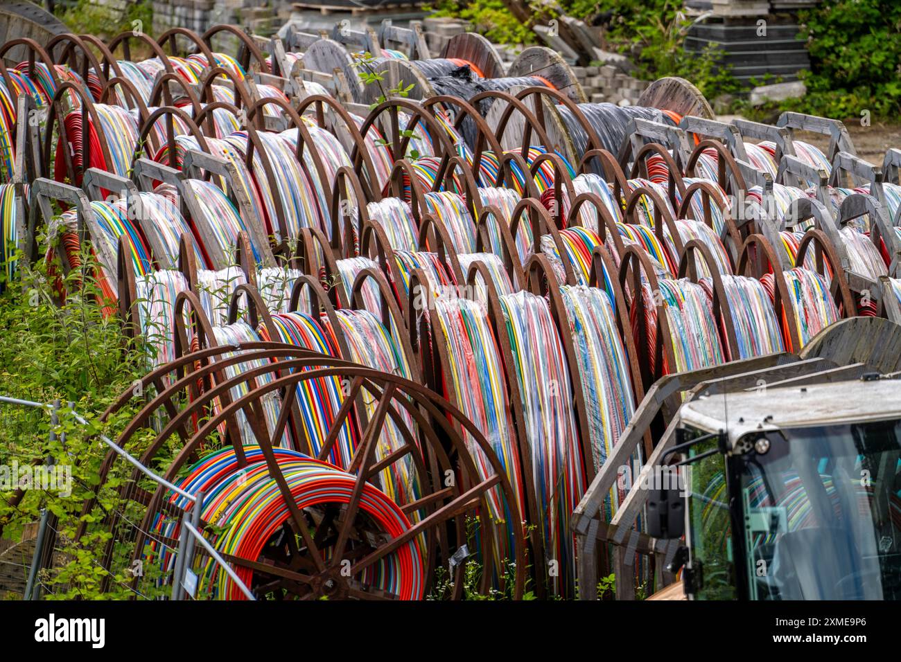 Cable drums with conduits for fibre optic cables, in a storage yard ...