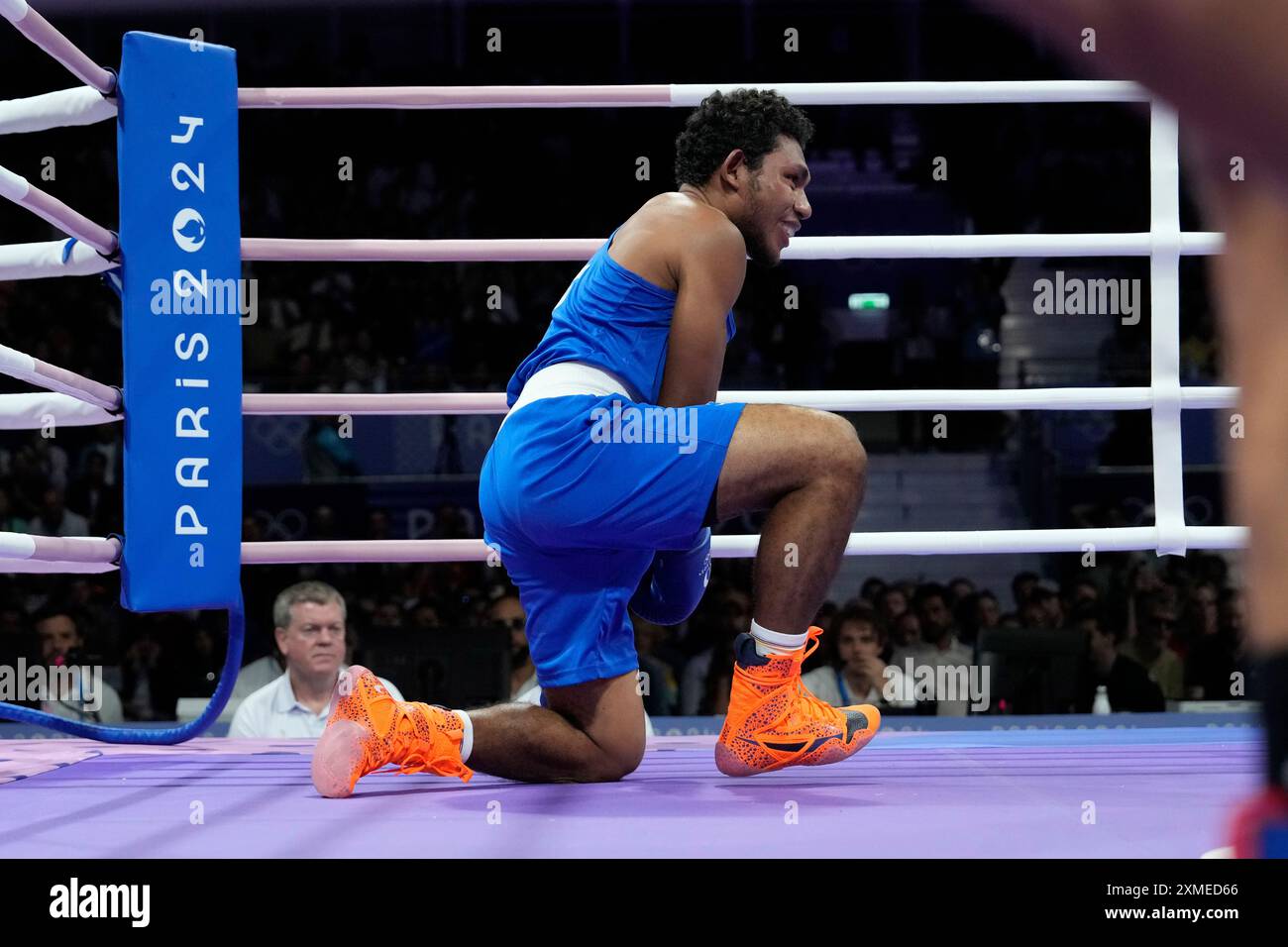 Papua New Guinea's John Ume knees on the mat after he was knocked down ...
