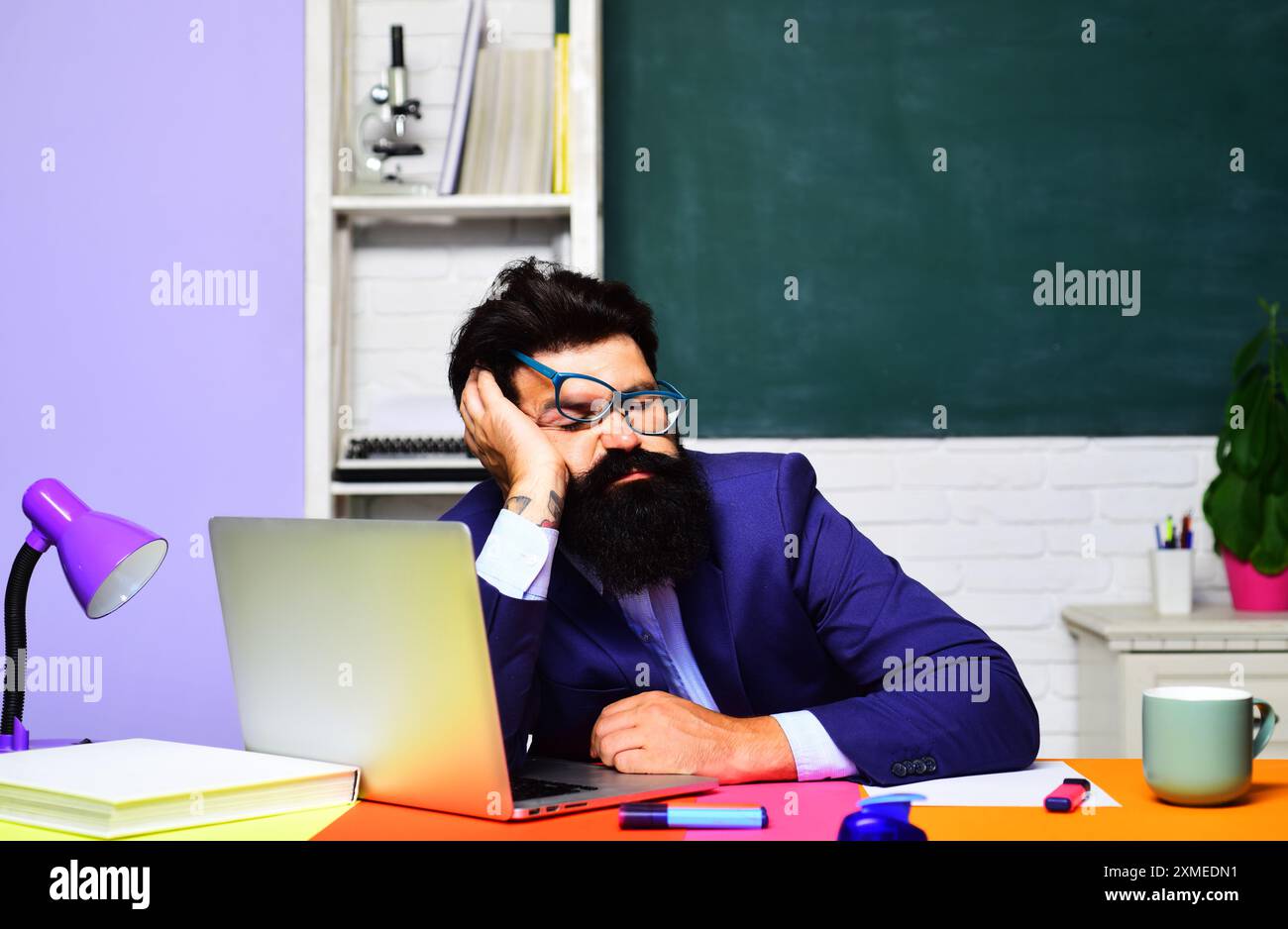 Fatigued male school teacher sleeping on desk. School break. Overworked ...