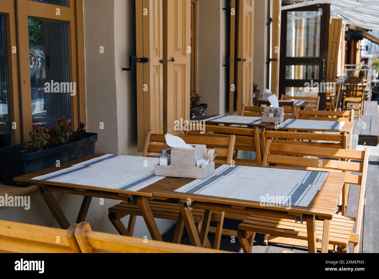 Outdoor empty coffee and restaurant terrace with wooden tables, vintage ...