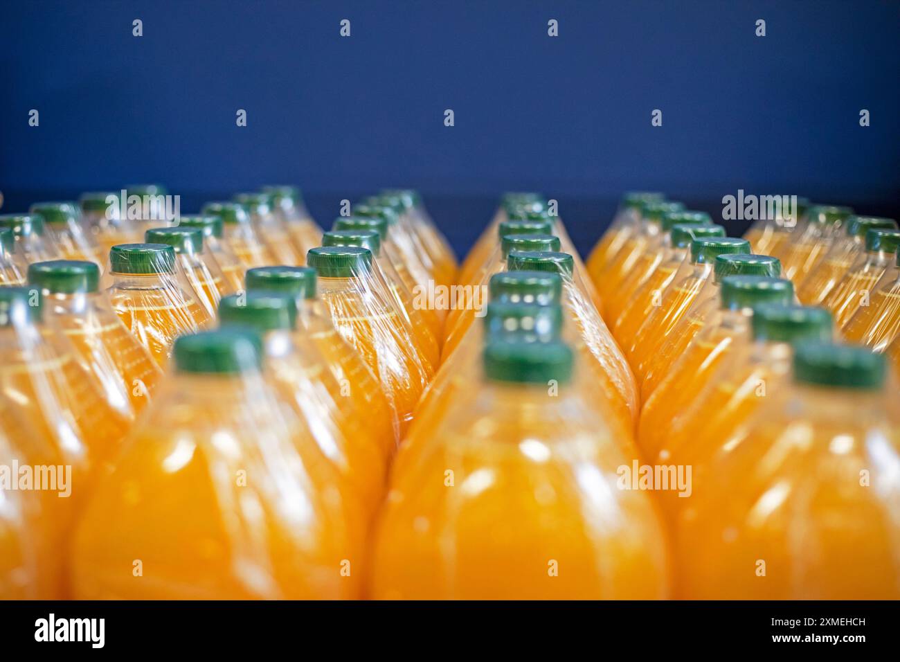 orange juice and other drinks packed in plastic containers with green ...
