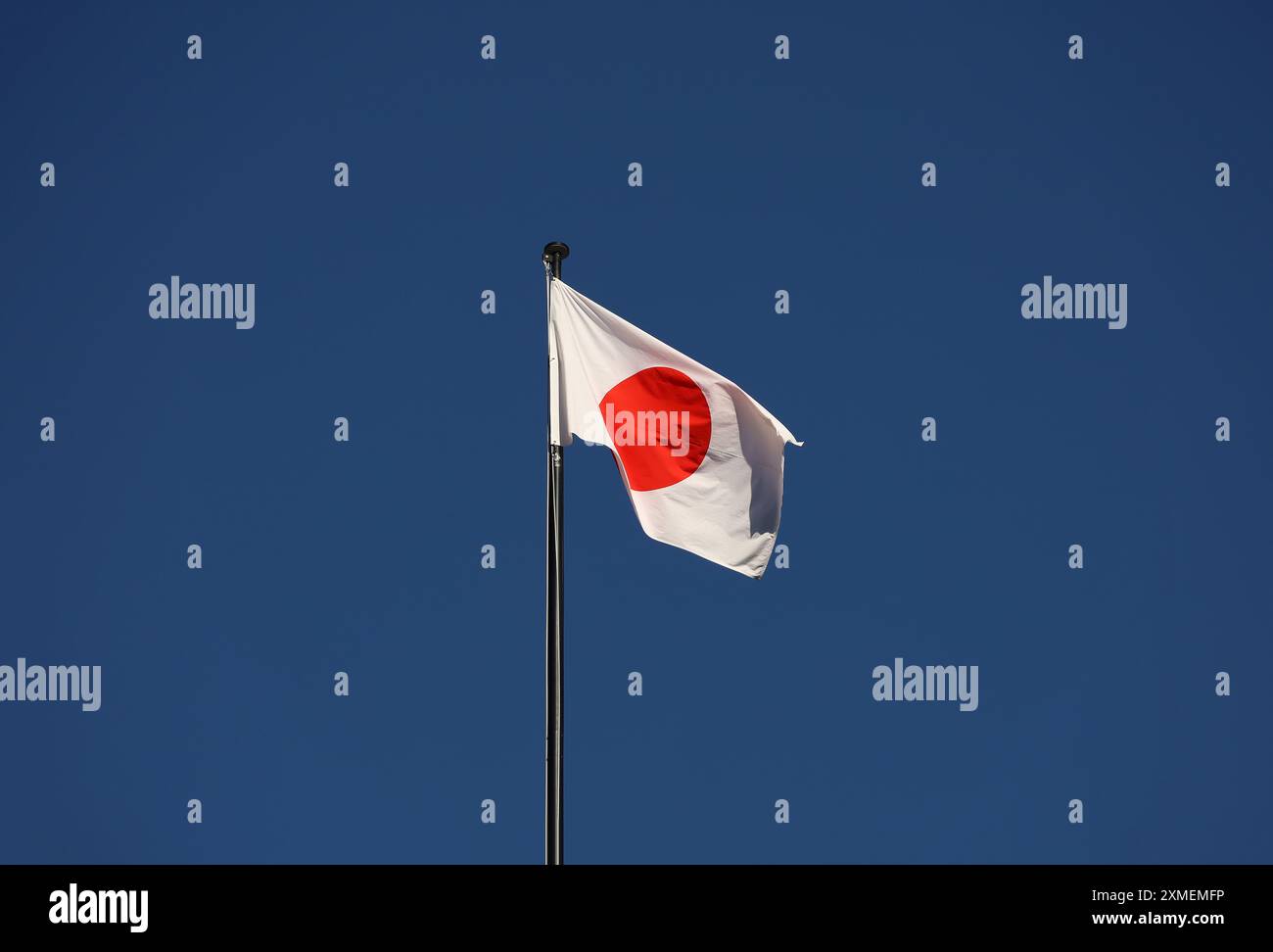 Japanese flag waving in the wind against a blue sky Stock Photo - Alamy
