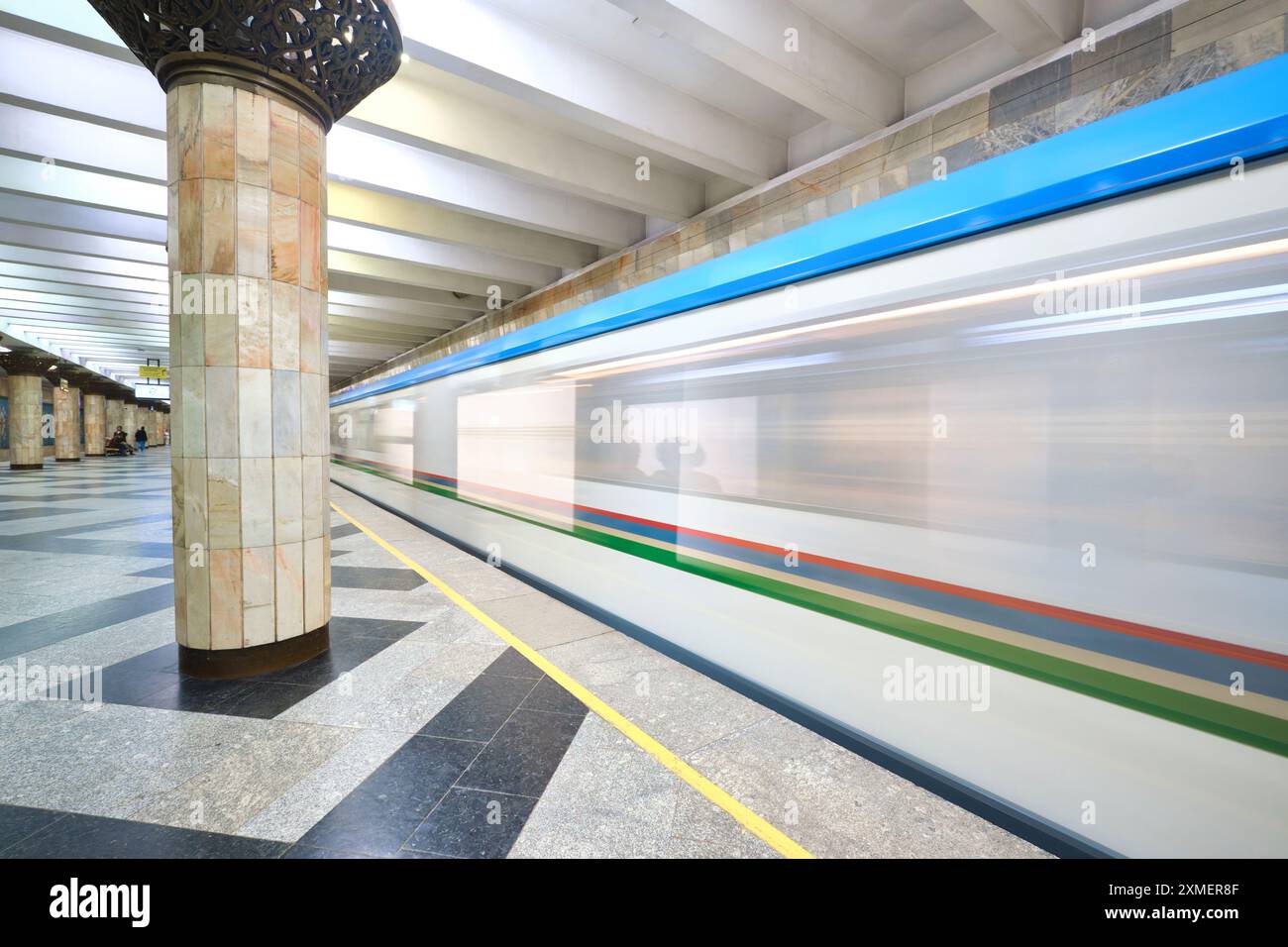 View of the station platform with an arriving train. At the Pakhtakor ...