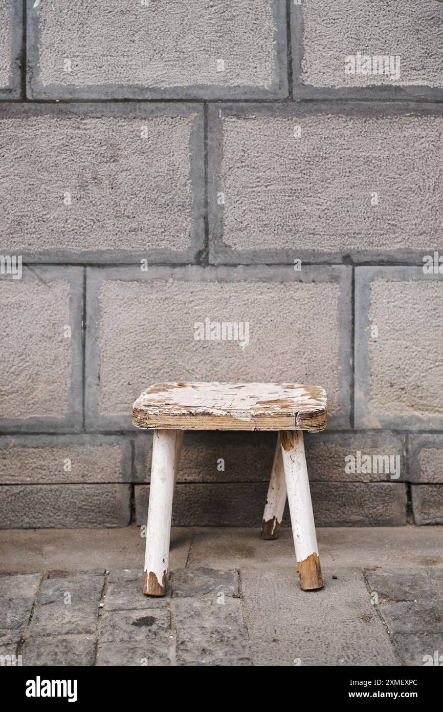 Vertical poster with old stool against concrete grey wall, recycling ...