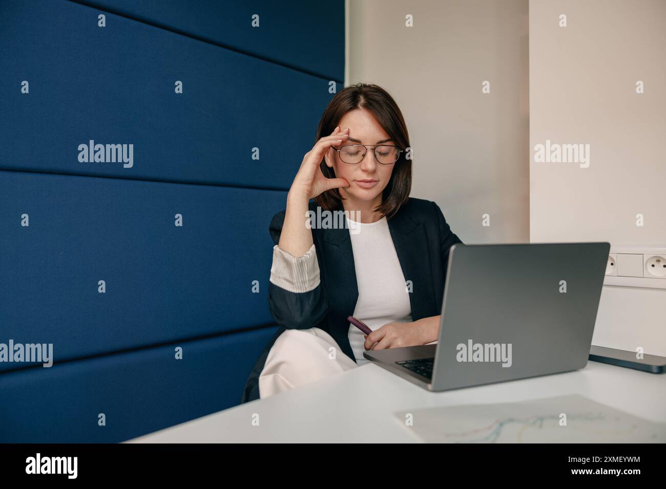 A stressed businesswoman is concentrating on her laptop work in the ...