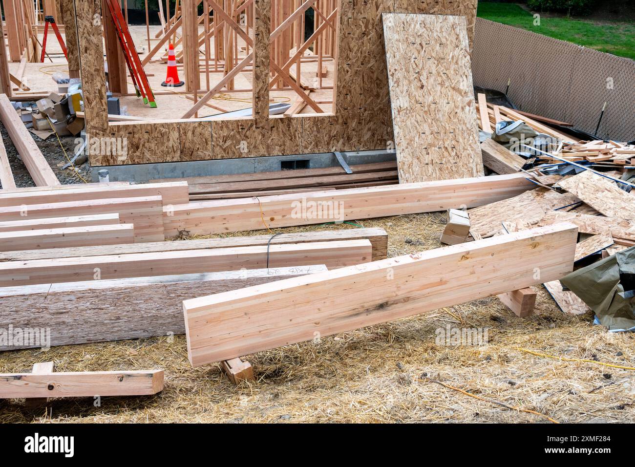 New home construction job site with newly delivered glue laminate beams, house wood framing ...